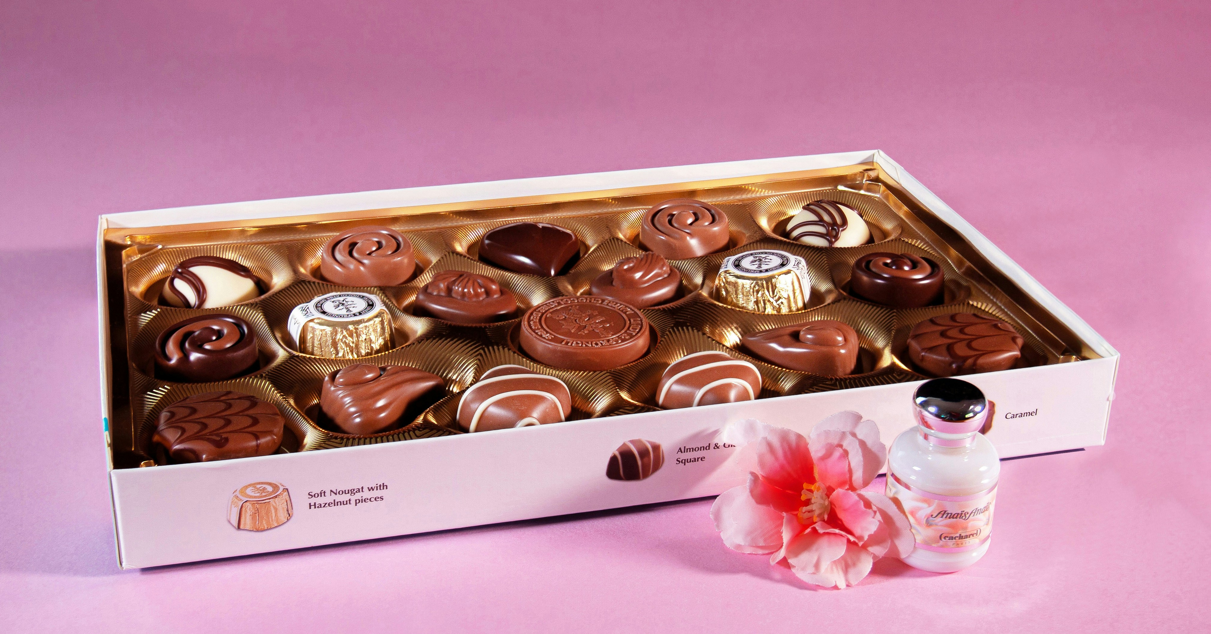 a box of chocolates with a pink flower