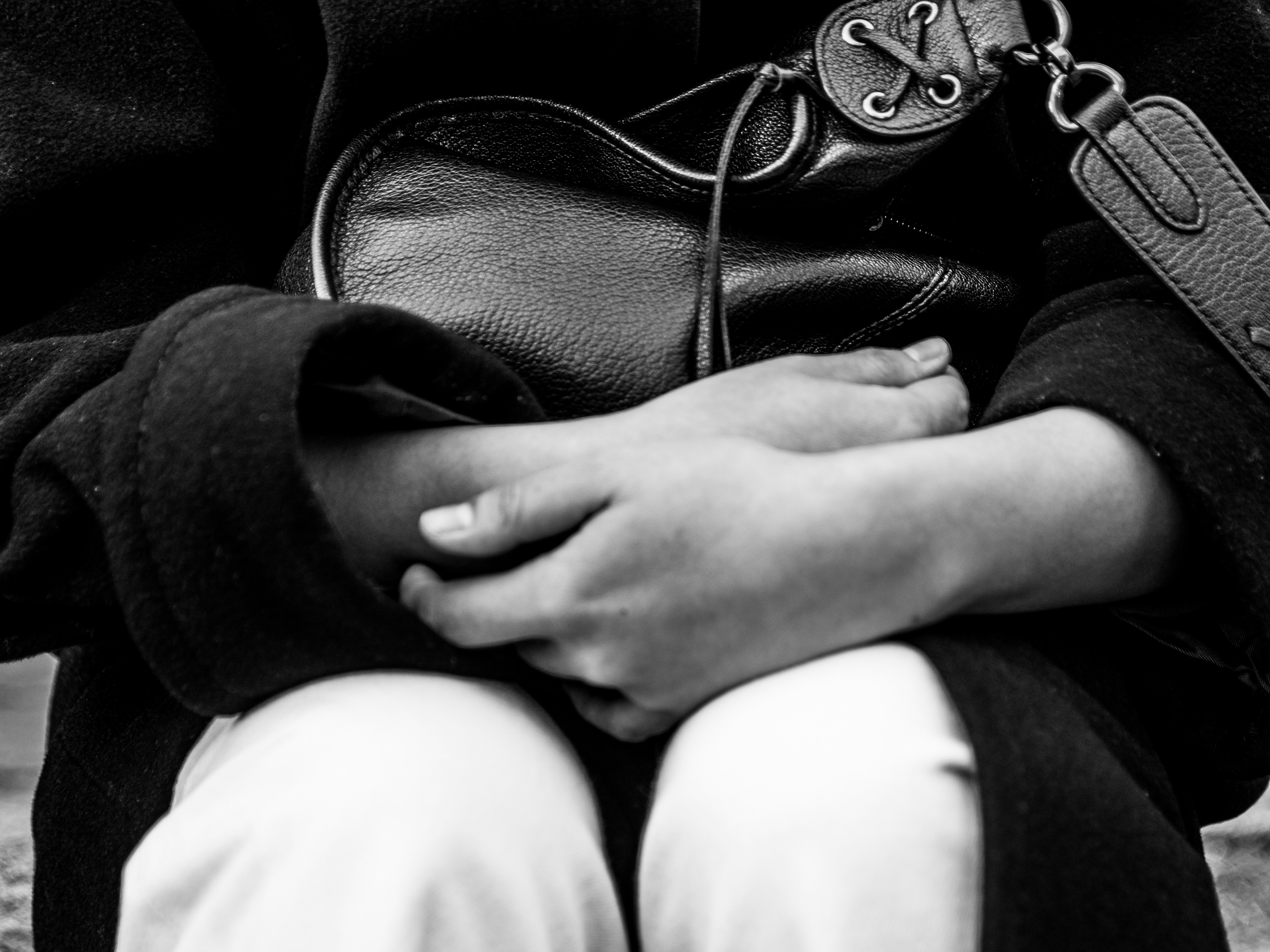 A black and white photo of a person holding a purse photo – Free Grey ...