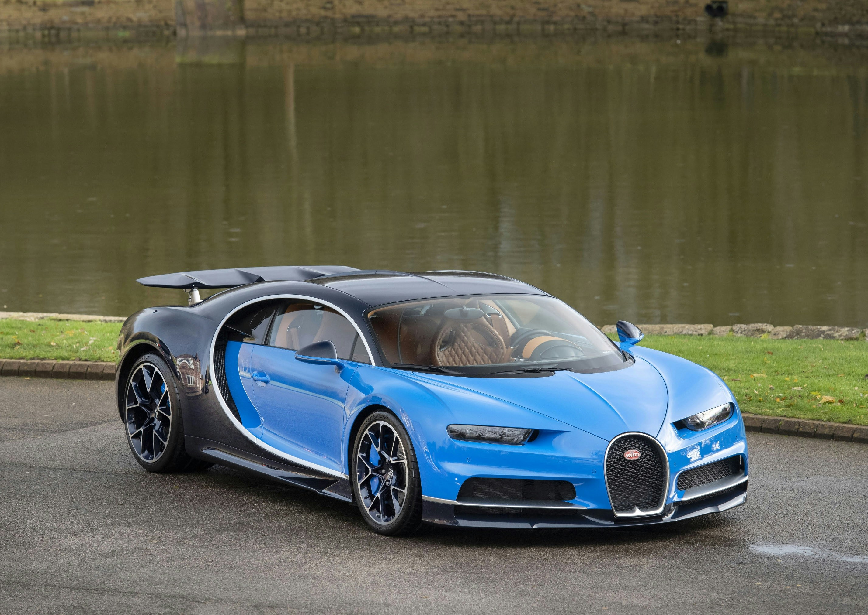 A blue bugatti is parked in front of a body of water photo – Free Blue ...