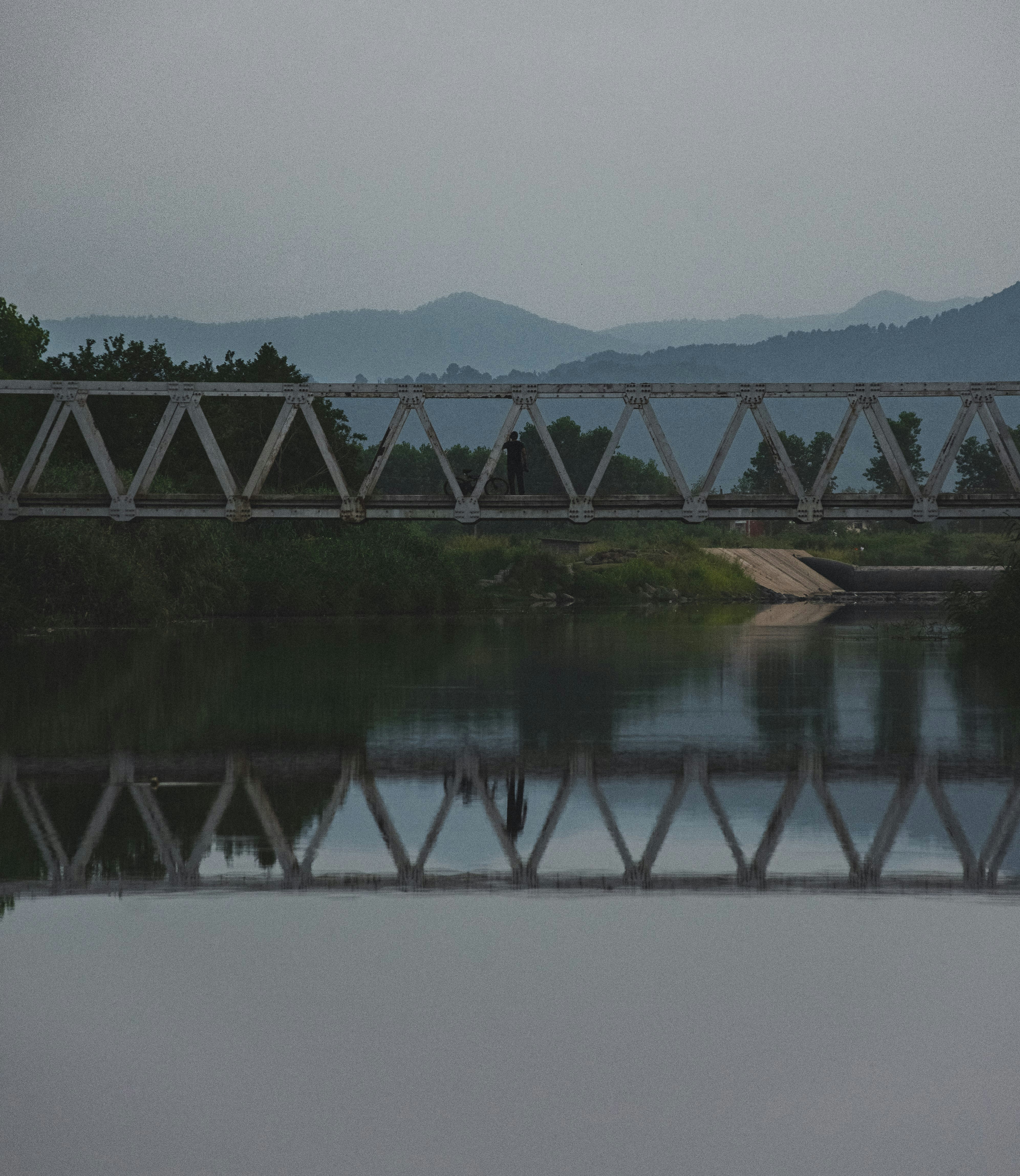 a person standing on a bridge over a river