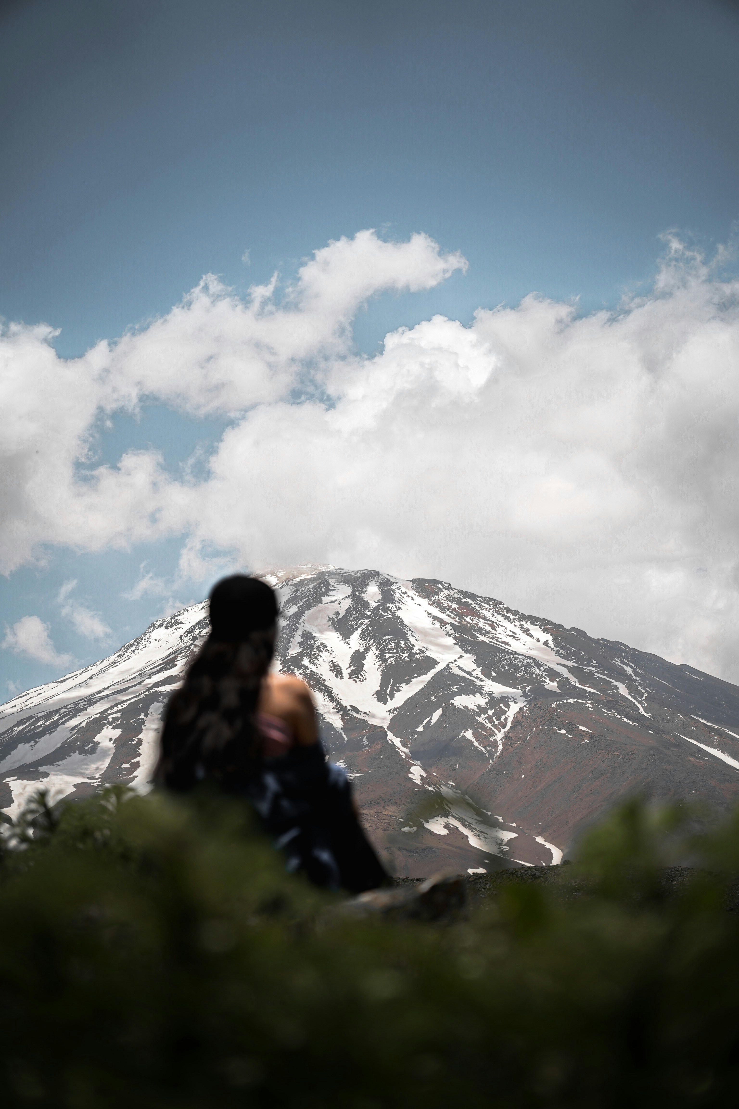 Horizon Gaze: A Figure Silhouetted Before a Snow-Capped Peak