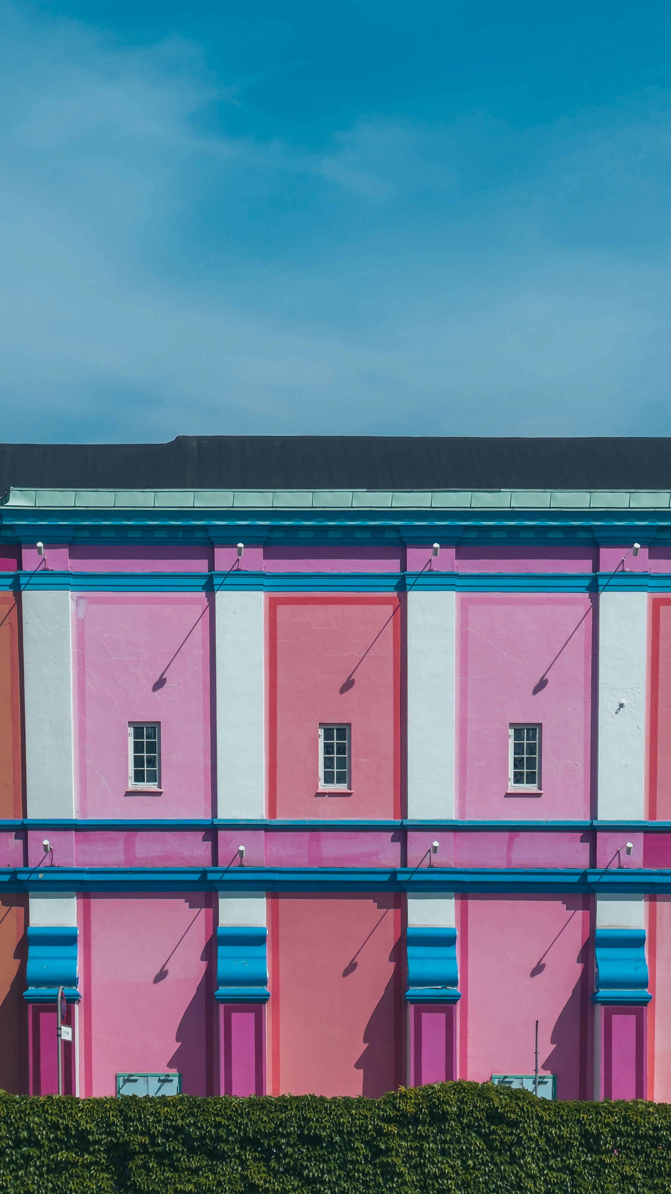 A pink and blue building with a black roof photo – Free Building Image ...