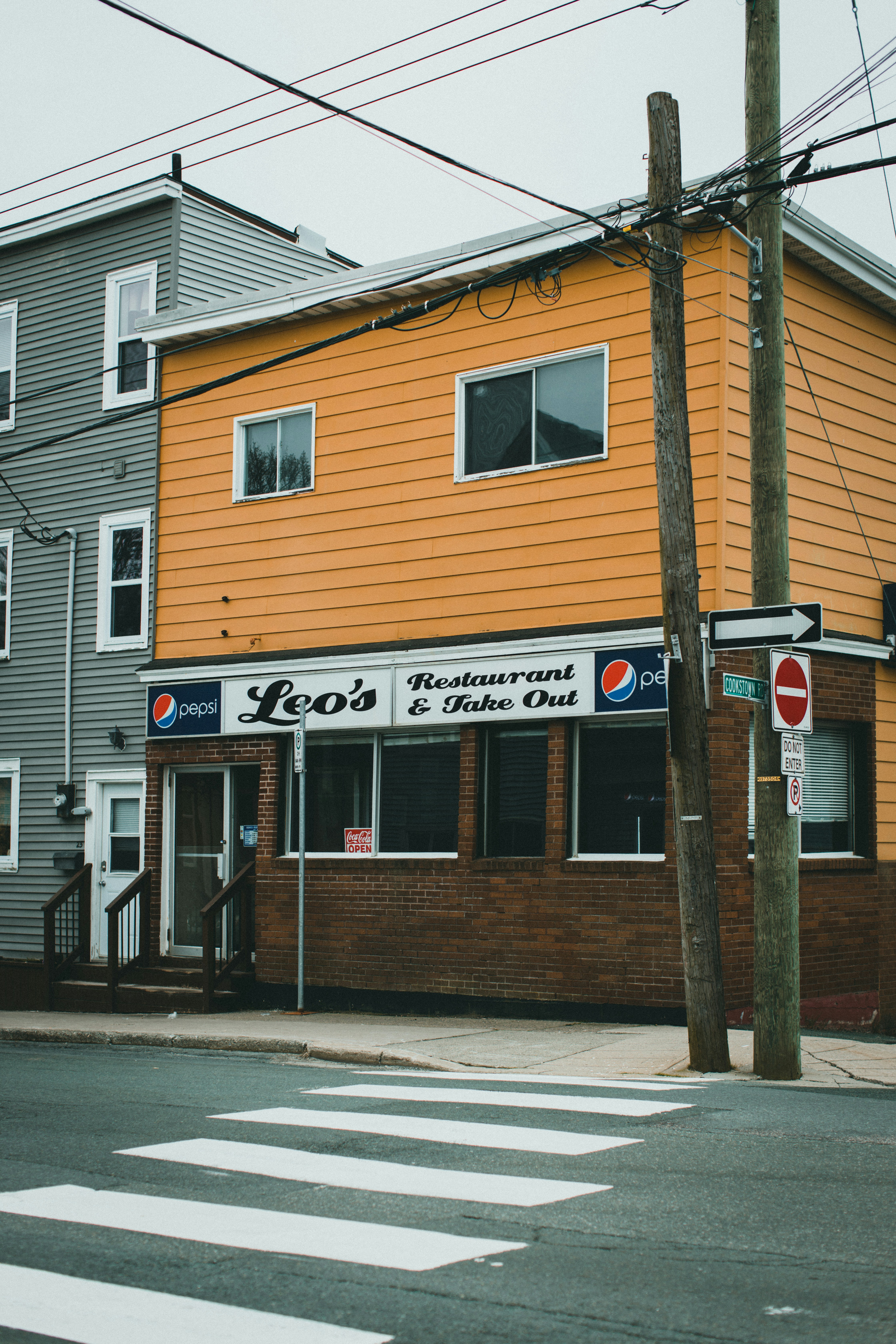 a yellow building with a pepsi sign in front of it