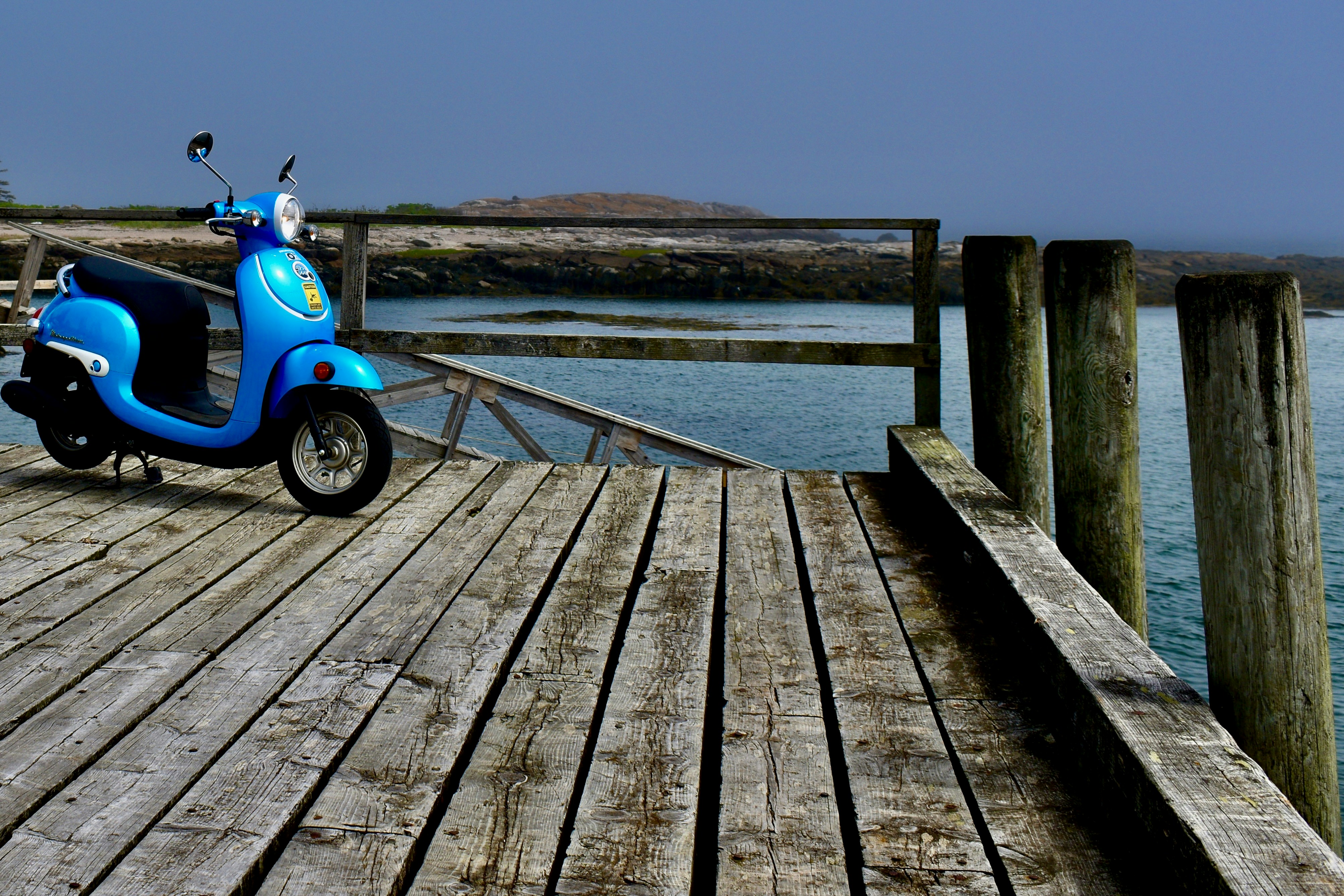 Blue Scooter at the Dock: Quiet Promenade by the Sea