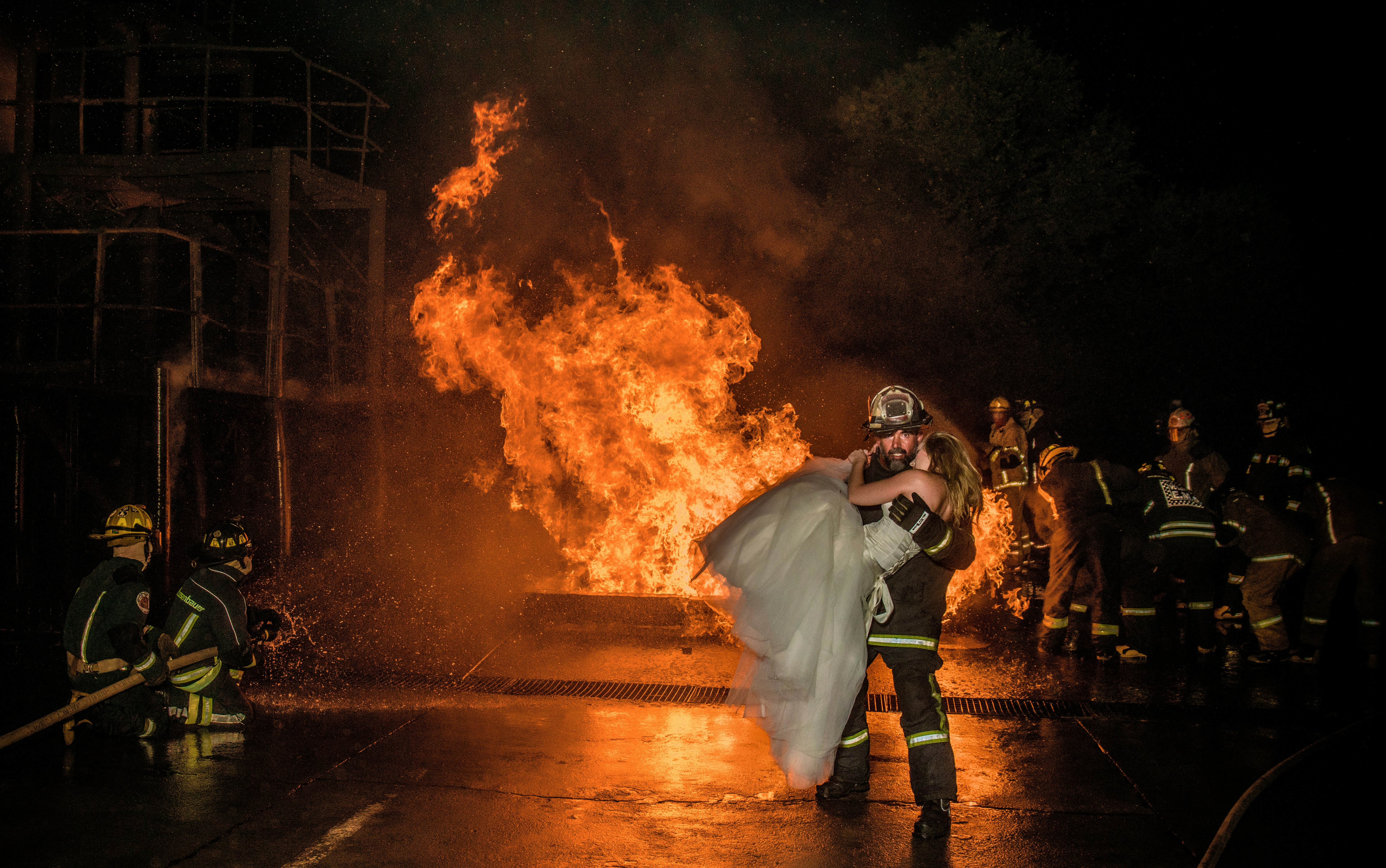 A bride and groom hug in front of a fire photo – Free Art Image on Unsplash