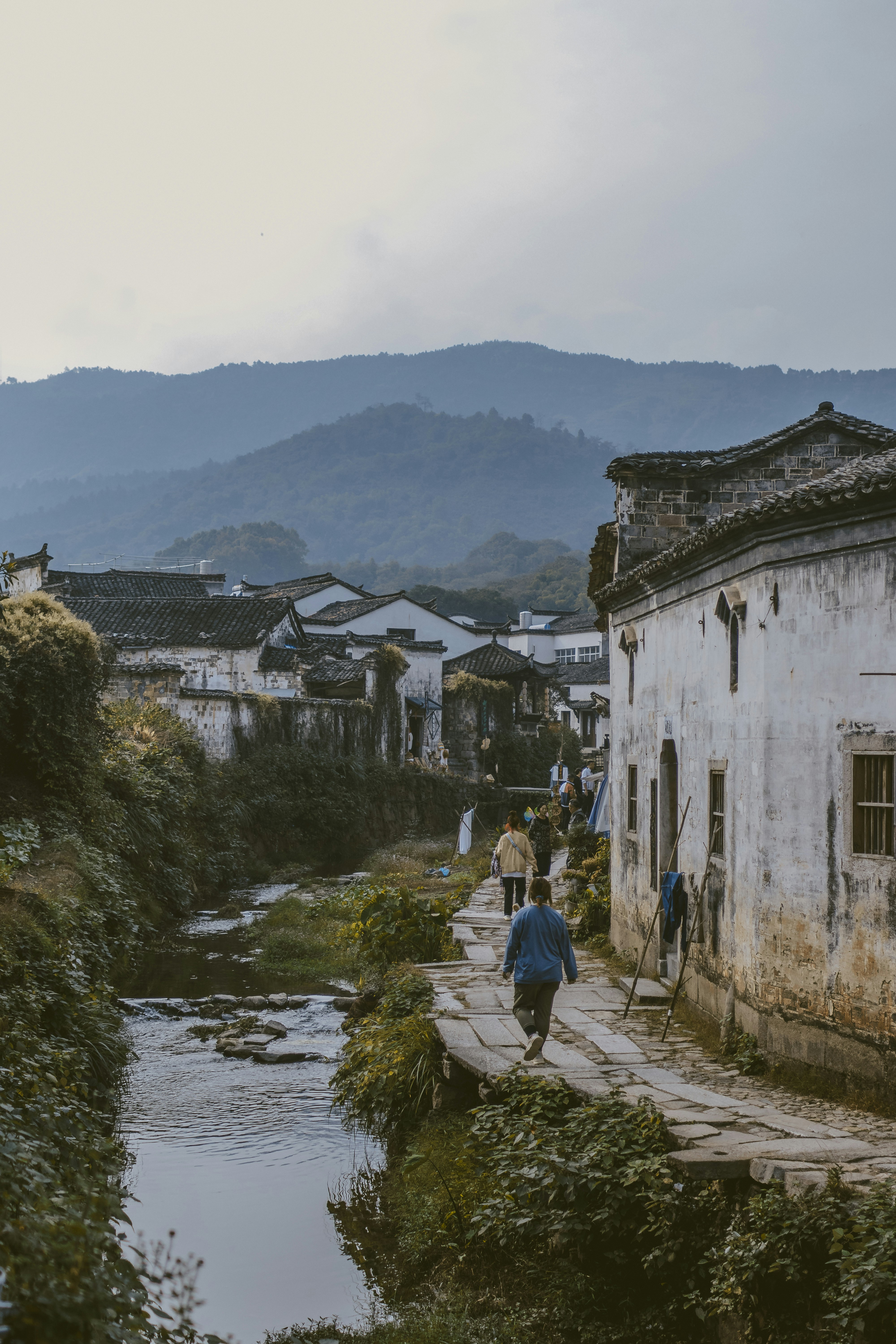 Footpath Through a Timeless Village: A Morning Walk by the Creek Beneath Distant Hills