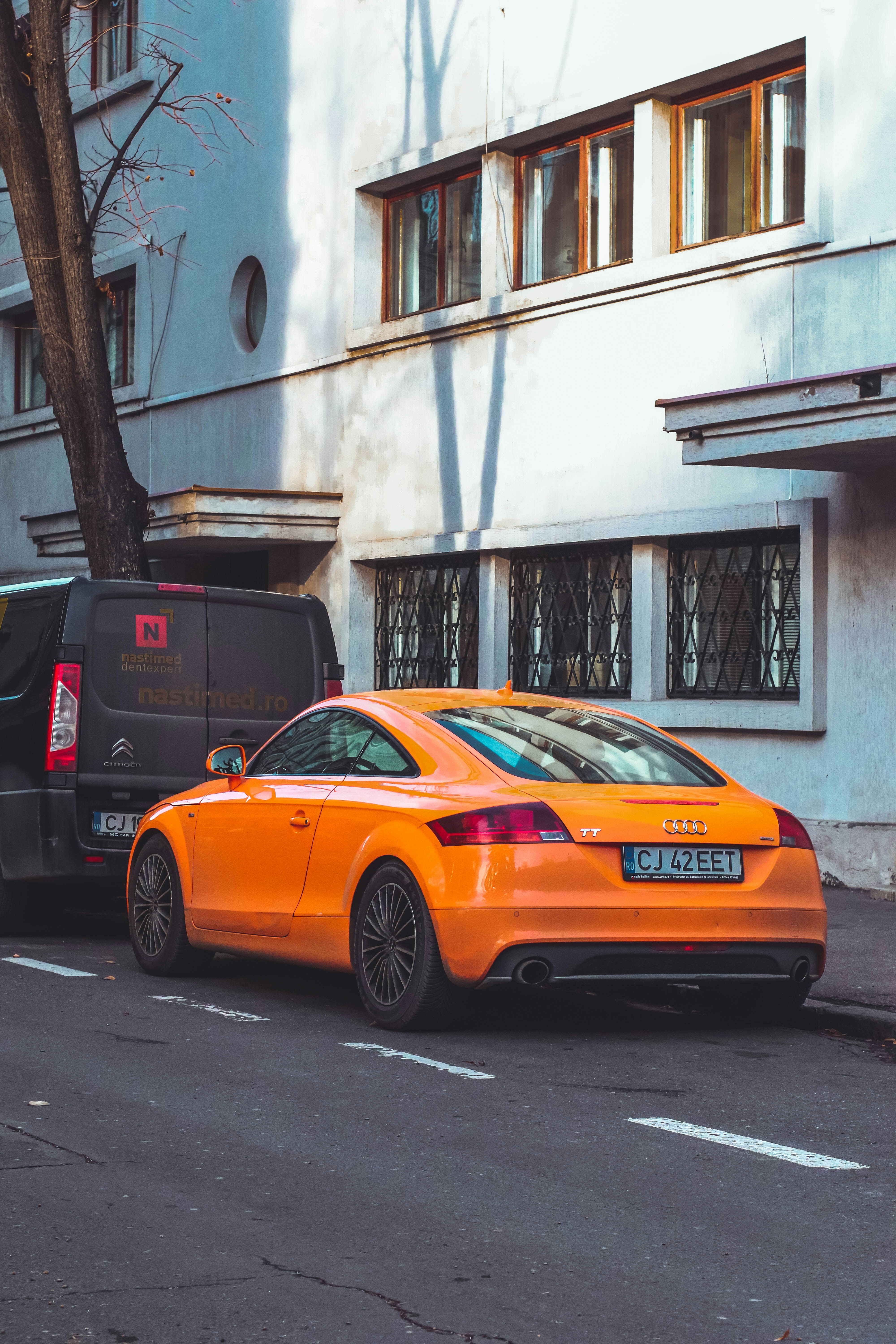 an orange car parked on the side of the road photo – Free Car Image on ...
