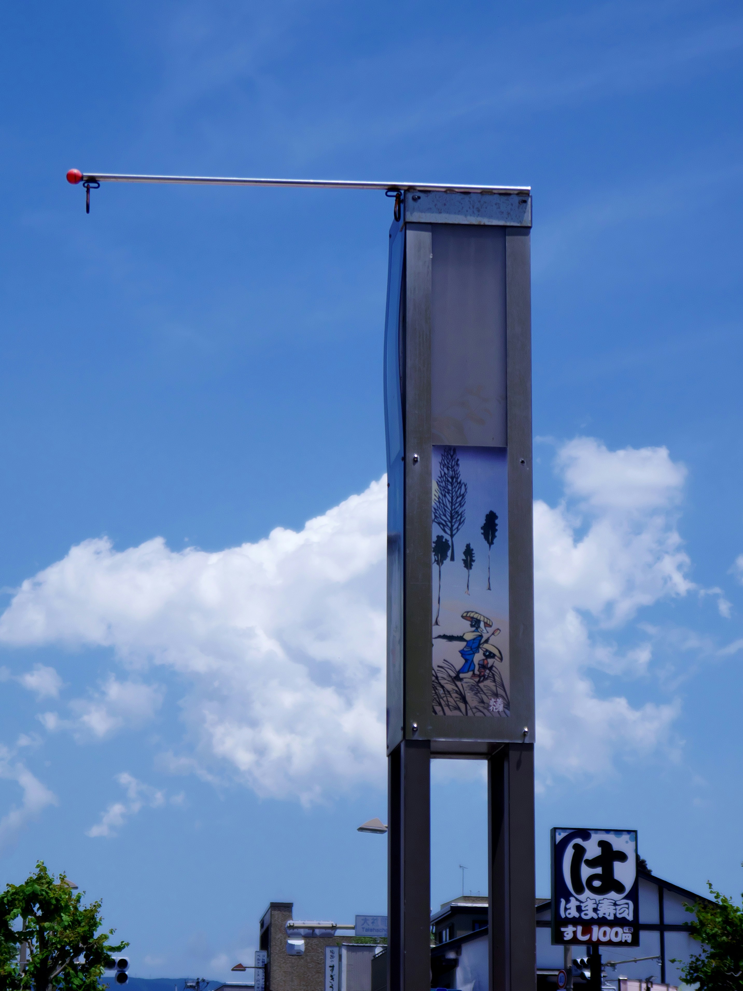 A weather vane featuring an illustrated figure in traditional attire, set against a vibrant blue sky with fluffy clouds.