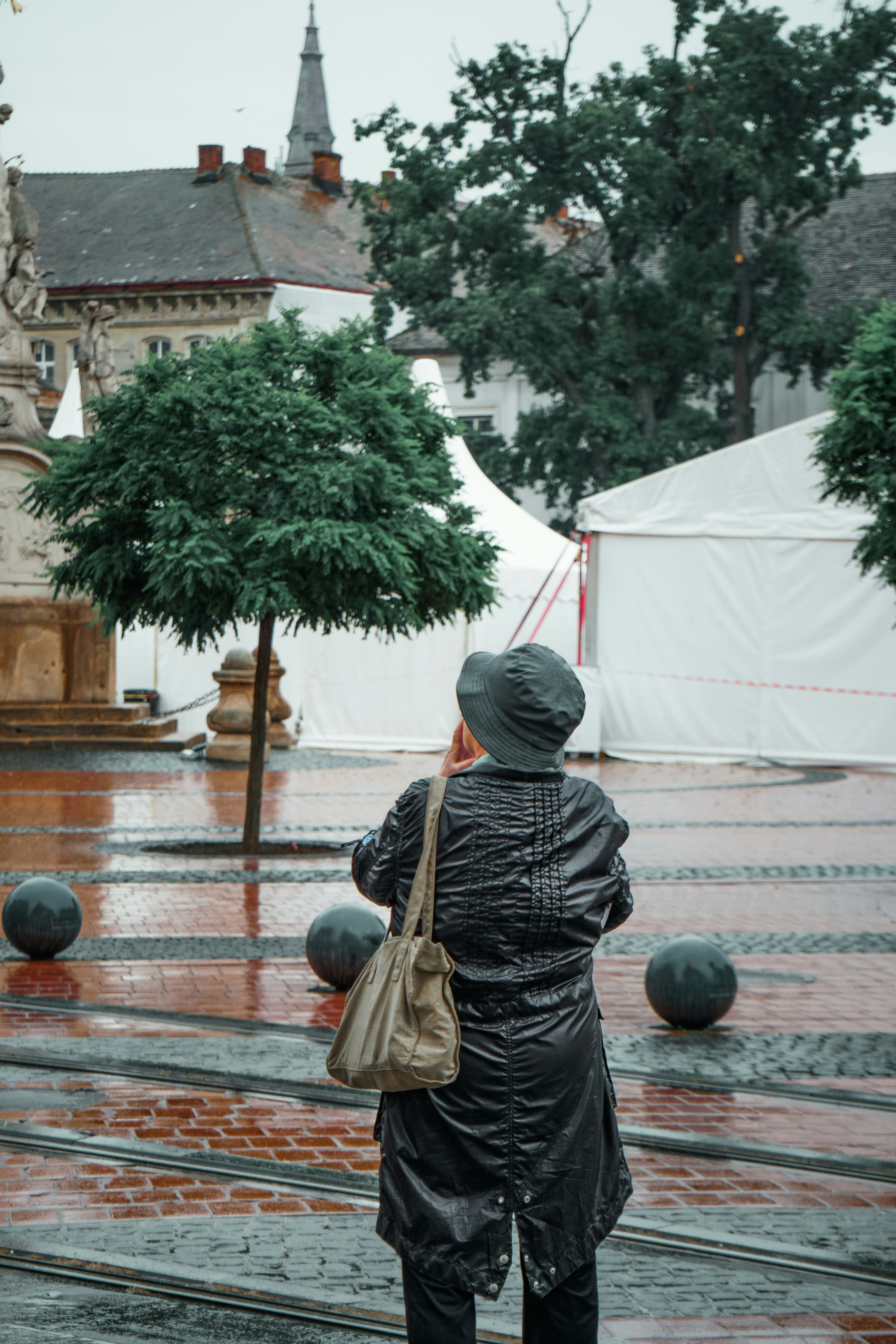 Urban Portrait in the Rain: A Woman in Black Trench and Wide-Brim hat