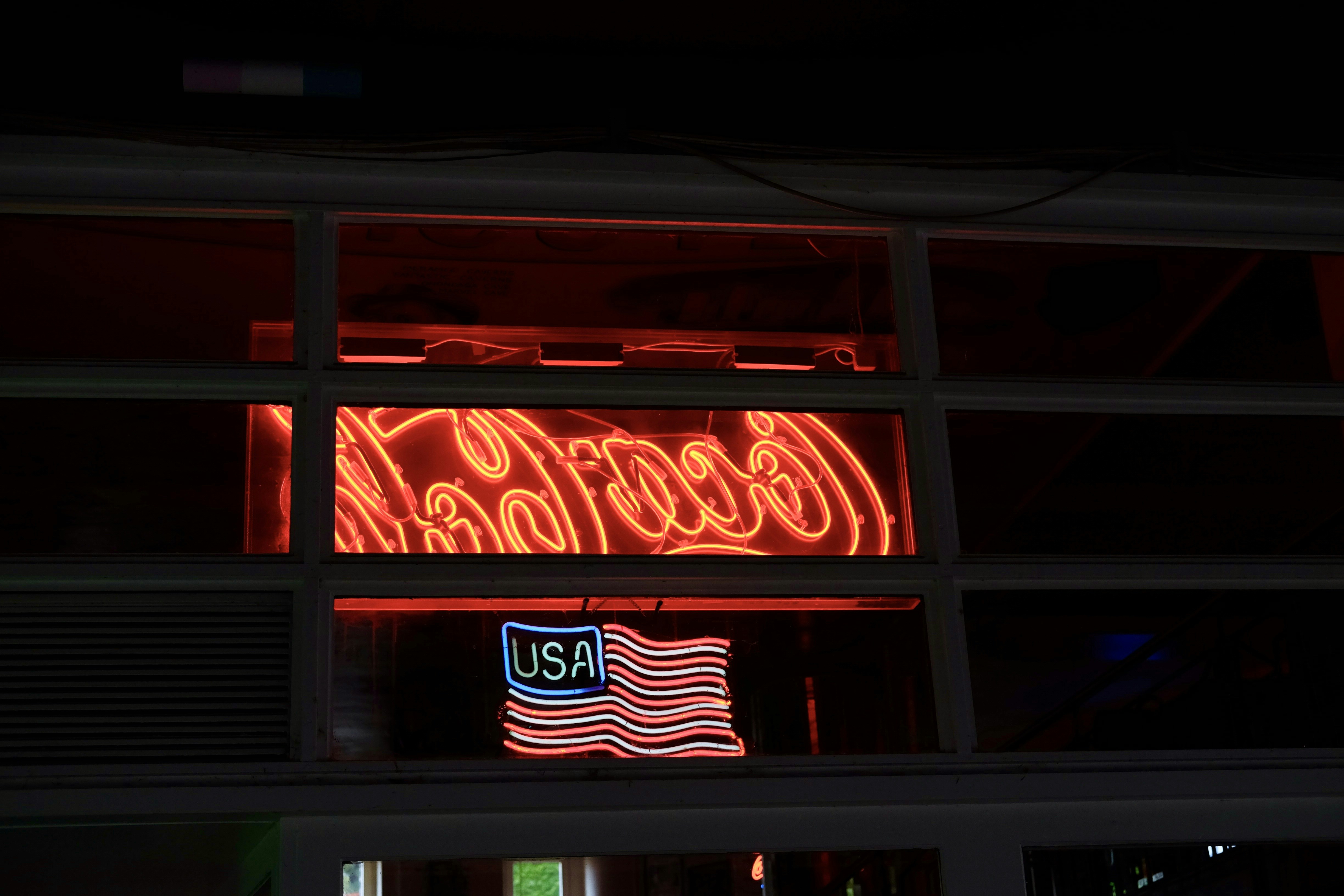 Neon Window Confluence: USA Sign Under a Crimson Glow
