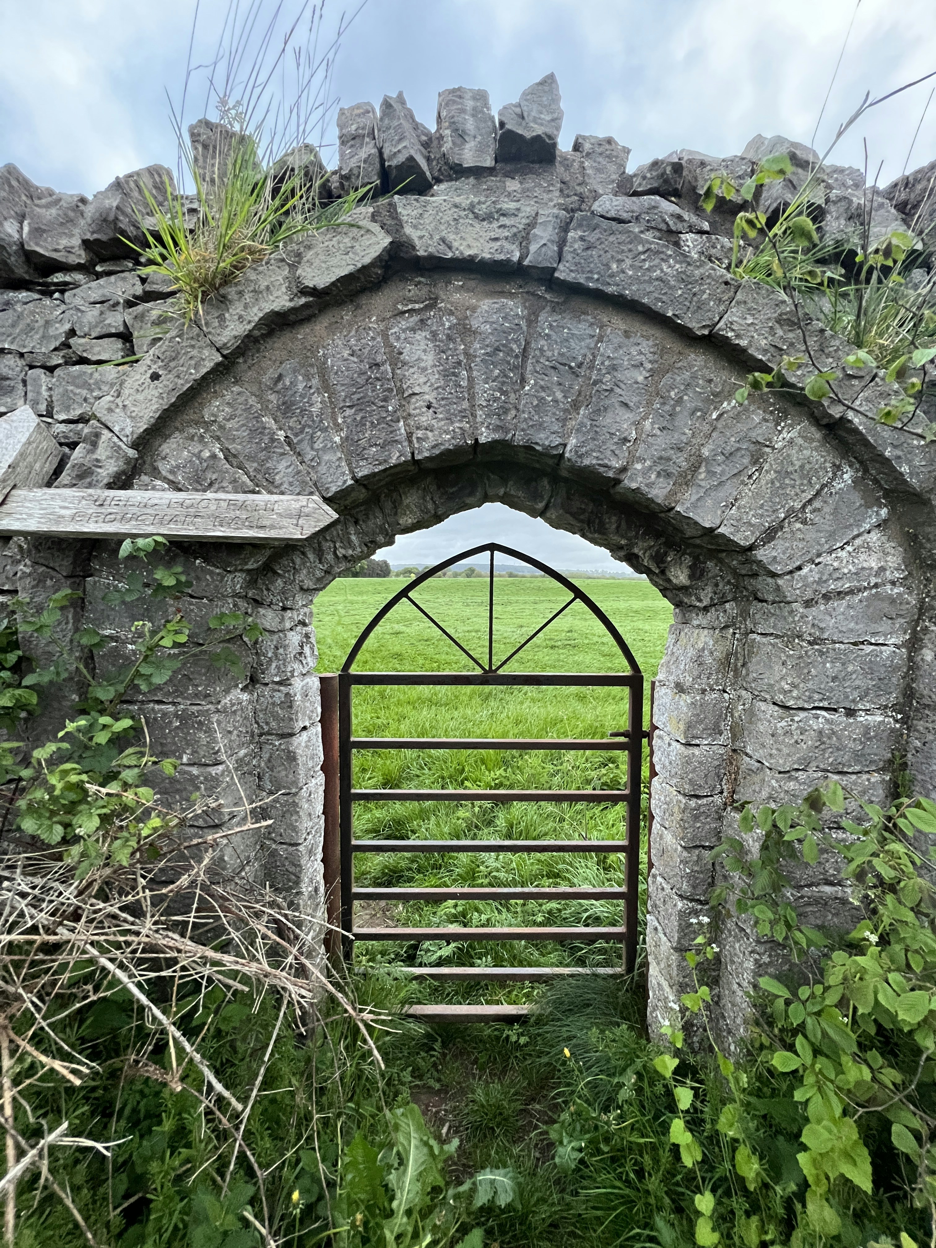 A stone arch with a gate in the middle of it photo – Free United ...