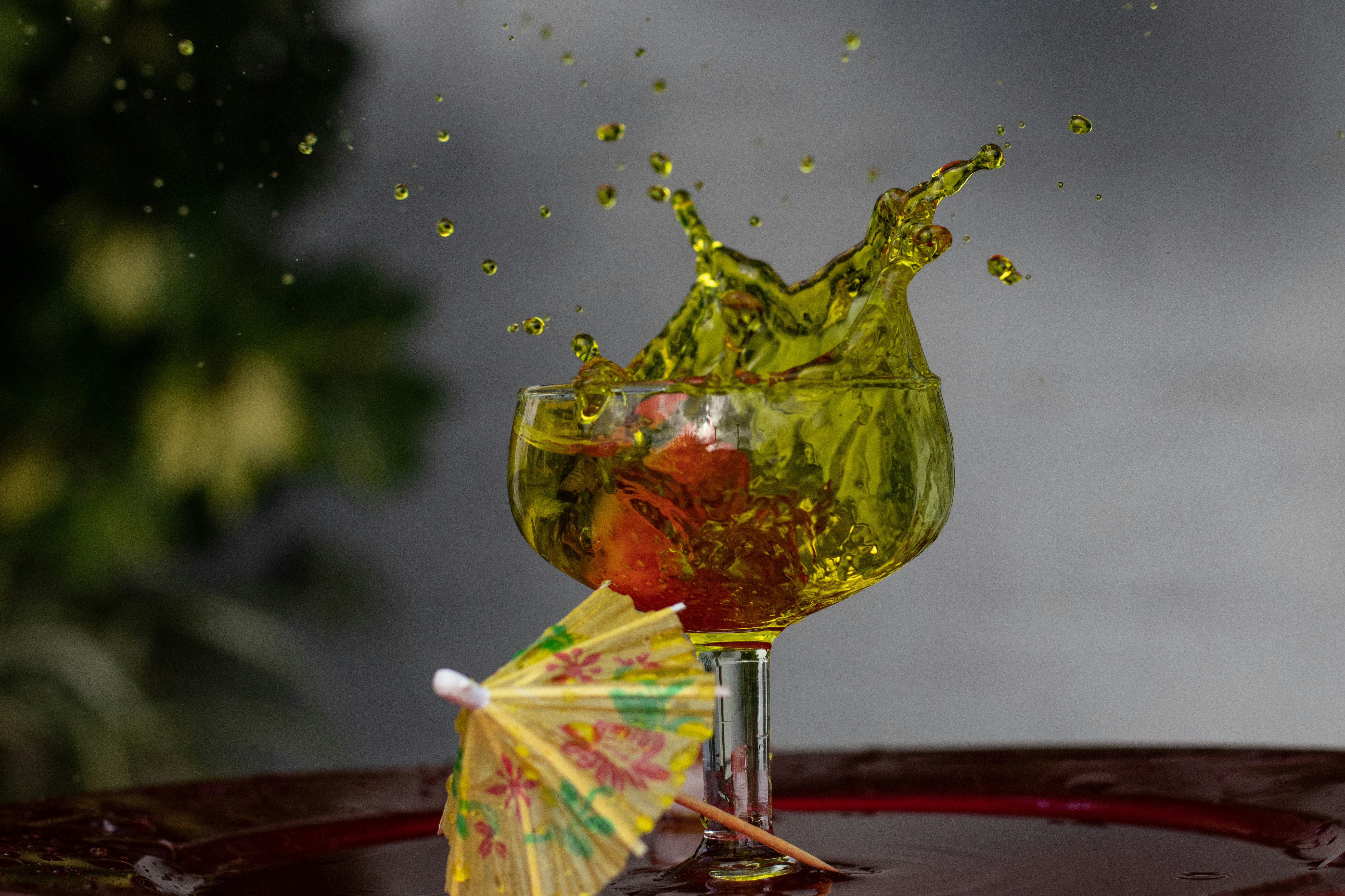 Citrus in Mid-Air: A Lime-Green Splash Over a Stemmed Glass