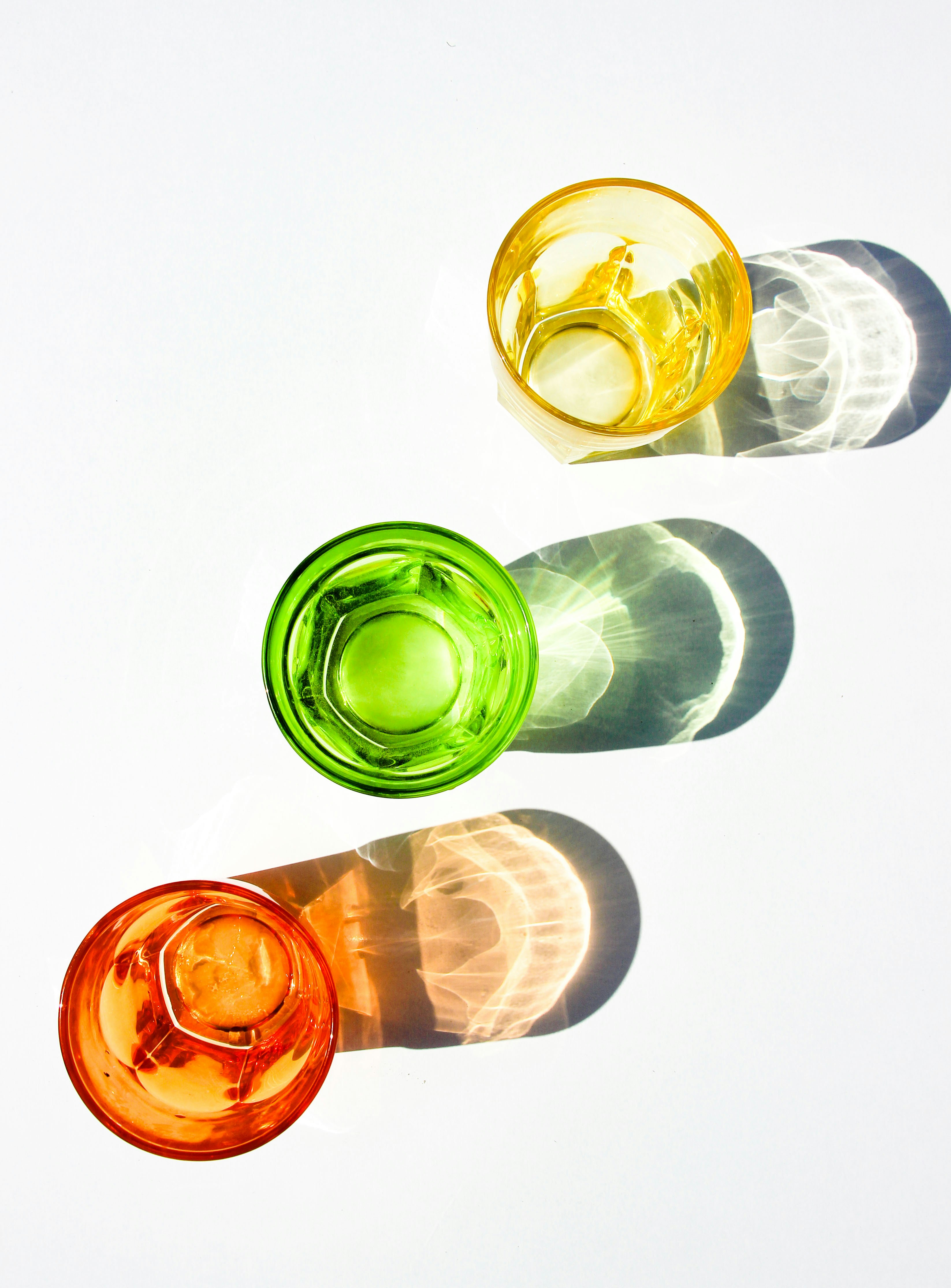 Three different colored cups sitting next to each other photo – Free ...