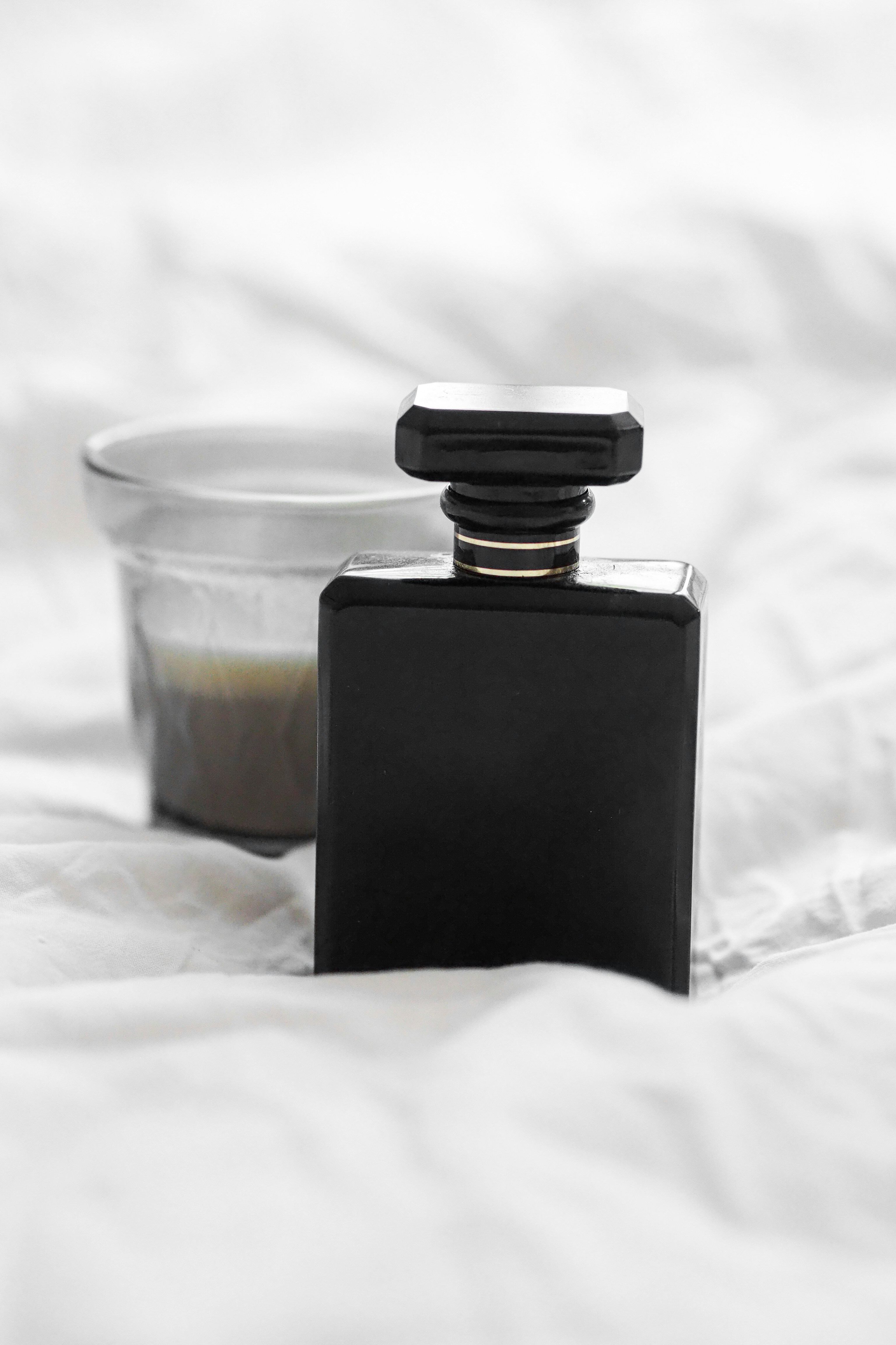 A bottle of perfume sitting on top of a bed photo – Free Black Image on ...
