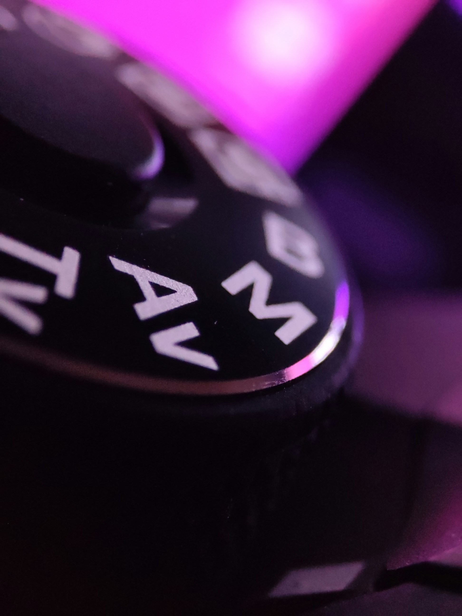 Violet Edge: A Macro Glimpse of a Camera Dial Under Neon Light