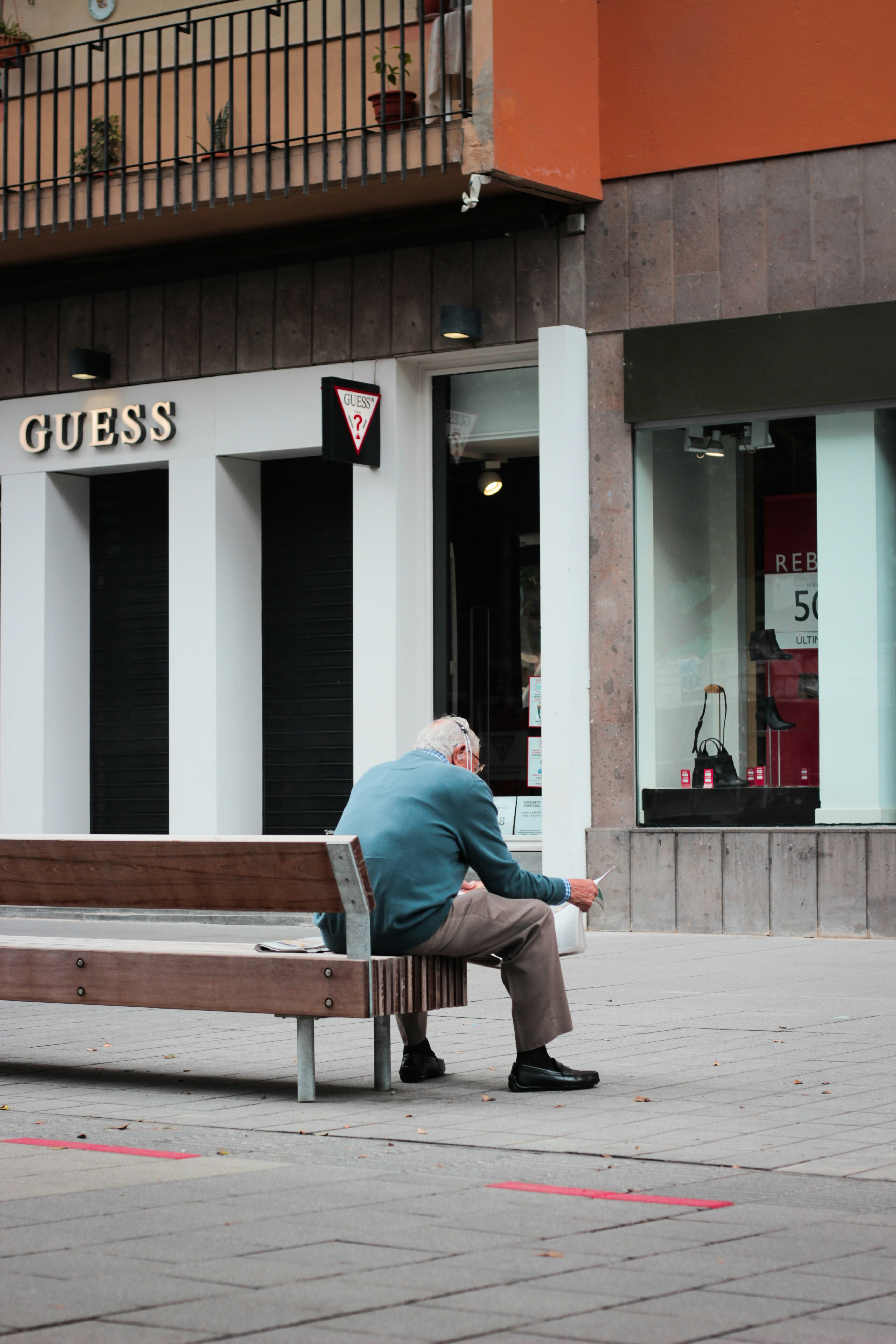 Blue-Sweater Pause on a City Block: Quiet Urban Light
