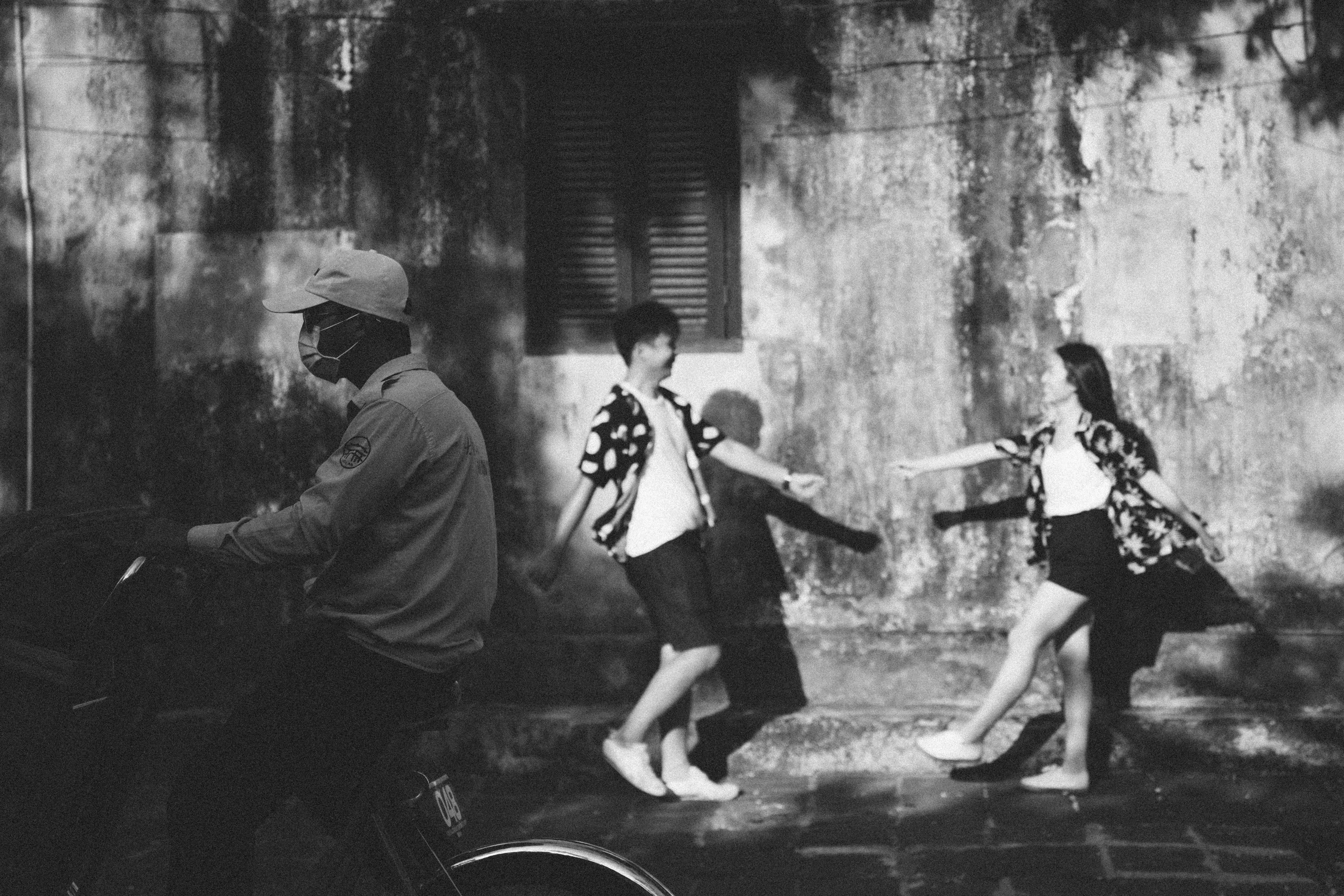 a black and white photo of people walking down the street