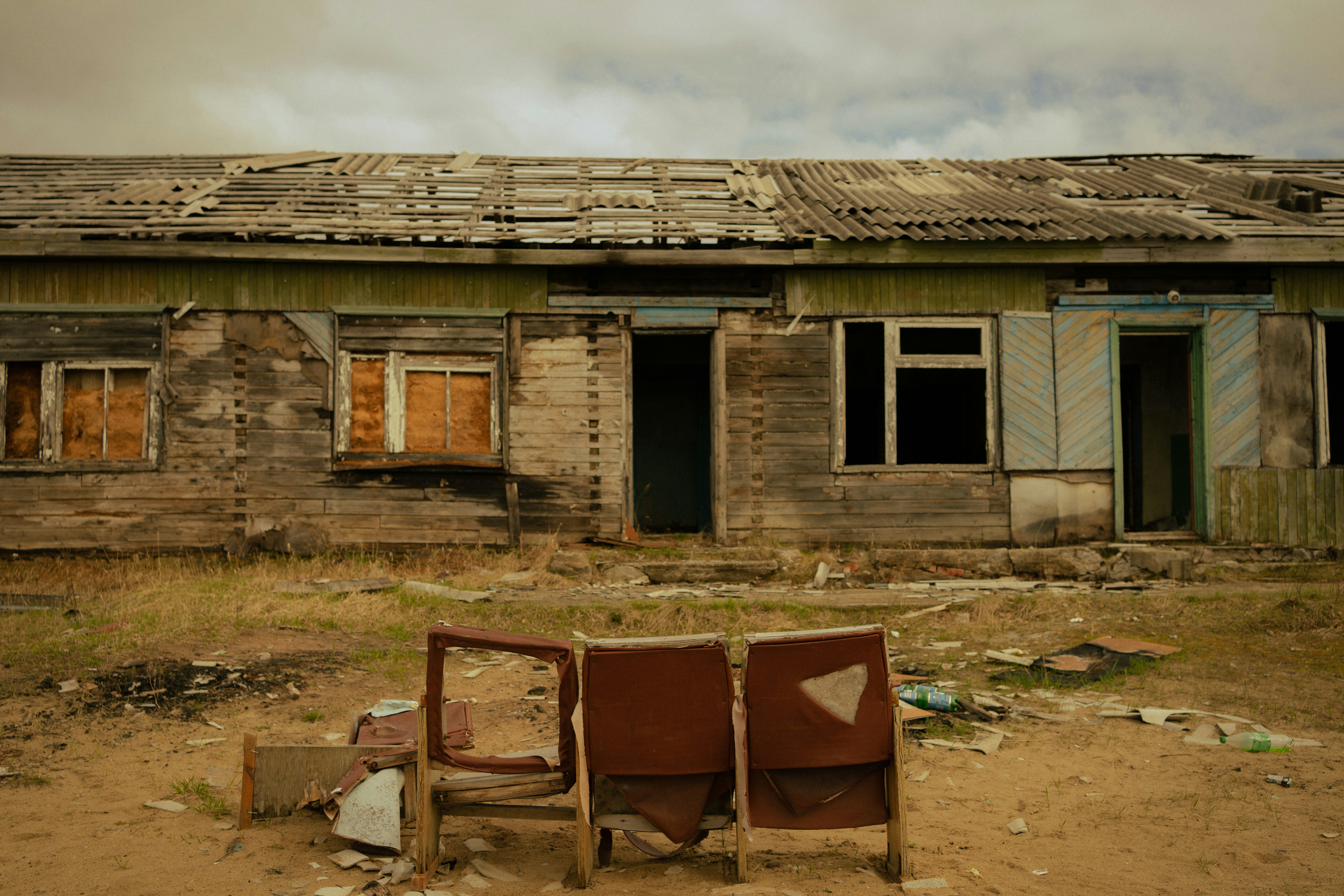 Foto Dos sillas sentadas frente a una casa deteriorada – Imagen ...