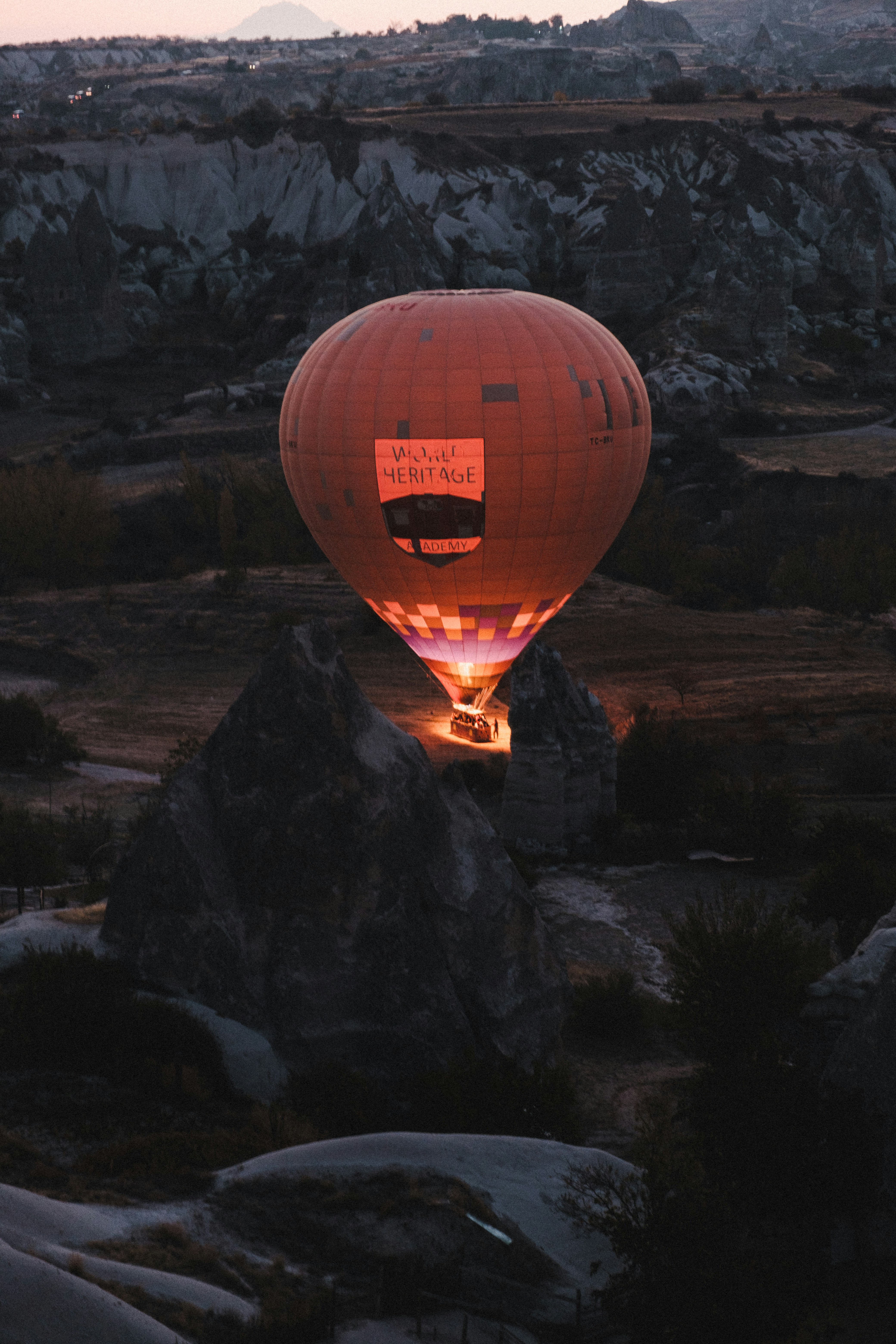 a hot air balloon flying over a rocky landscapeBechir Kaddech