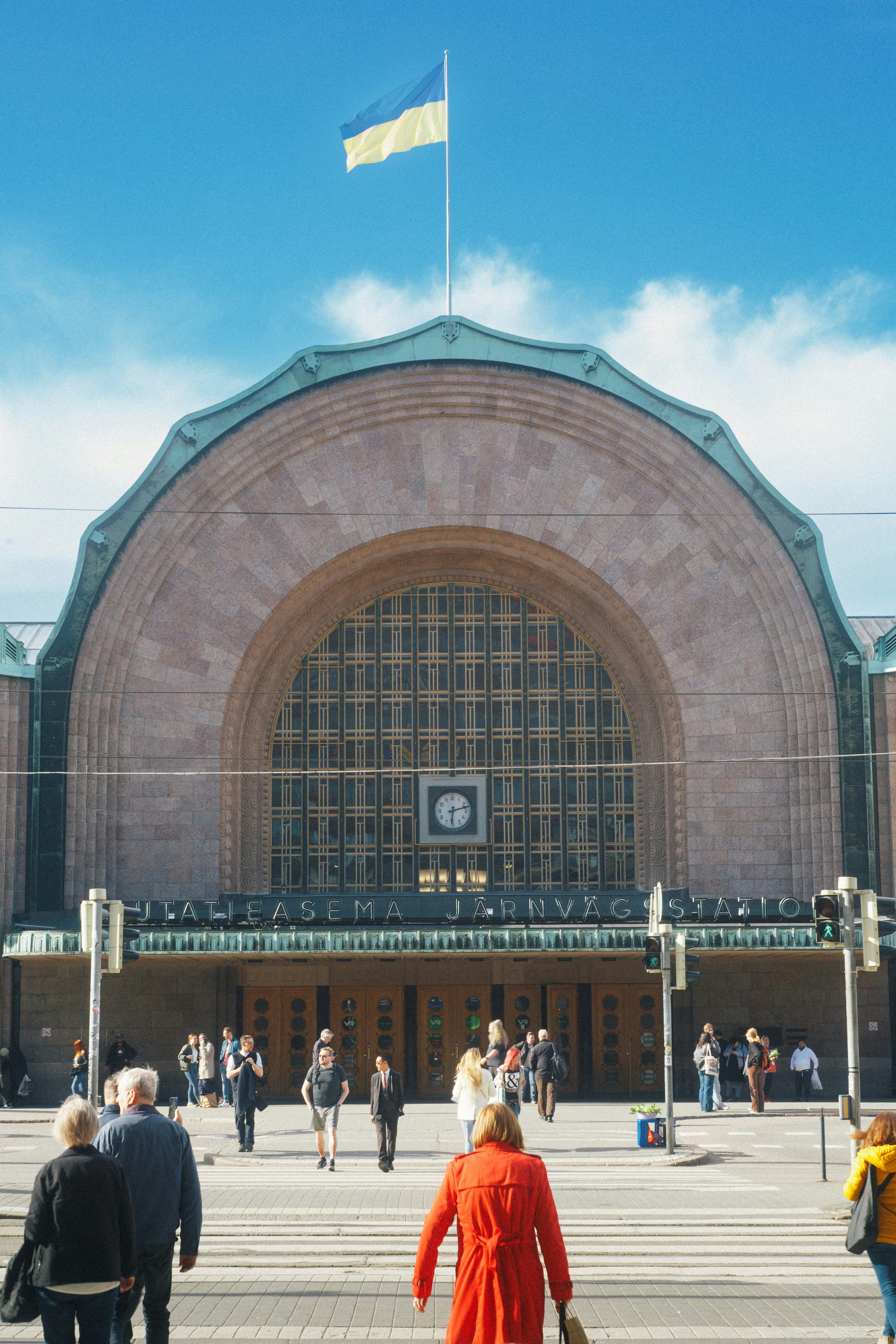 Brick Archway and Morning Footfall at a Flag-Topped Station