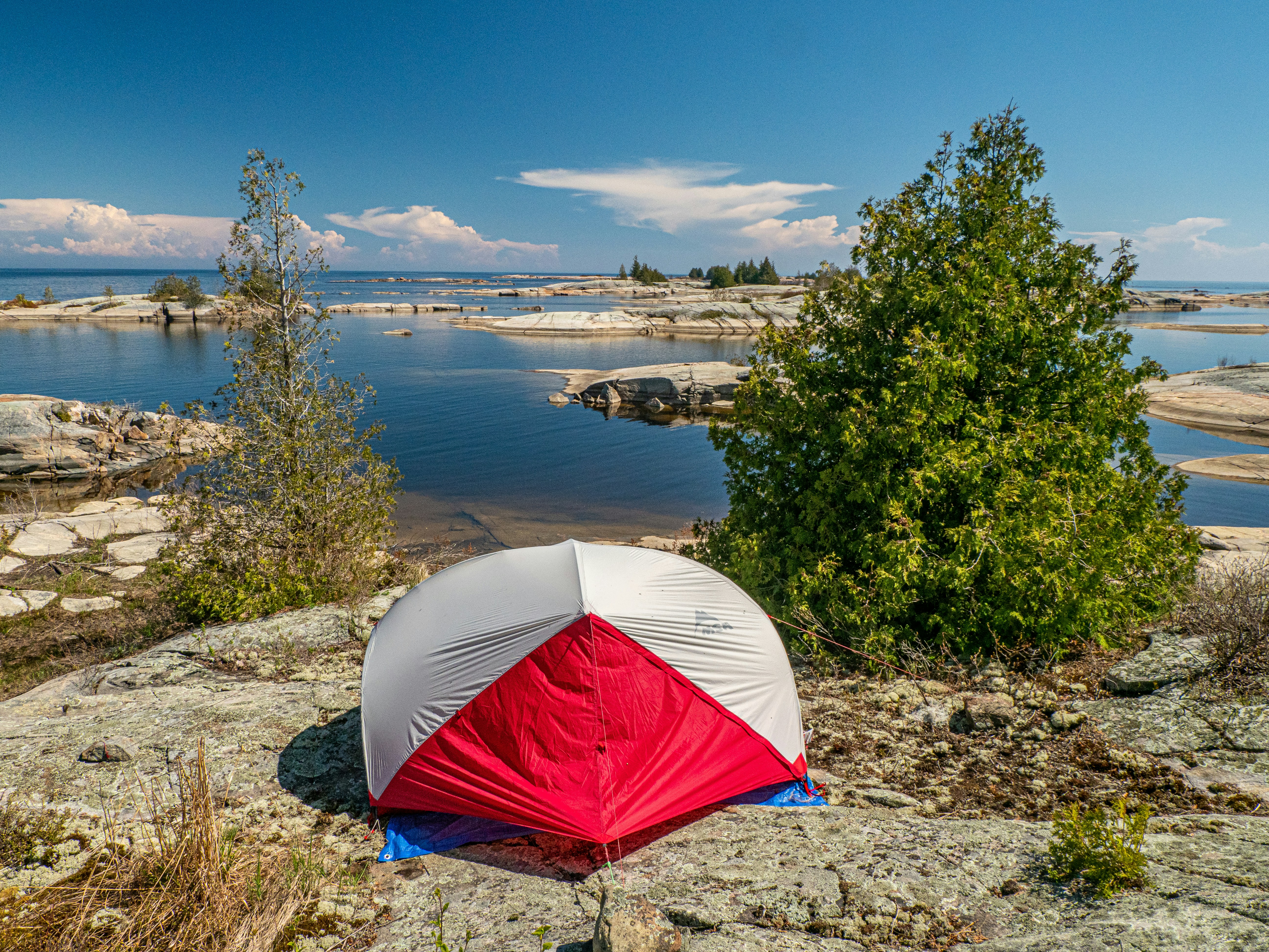 Une tente rouge et blanche posée au sommet d’un rocher photo – Image ...