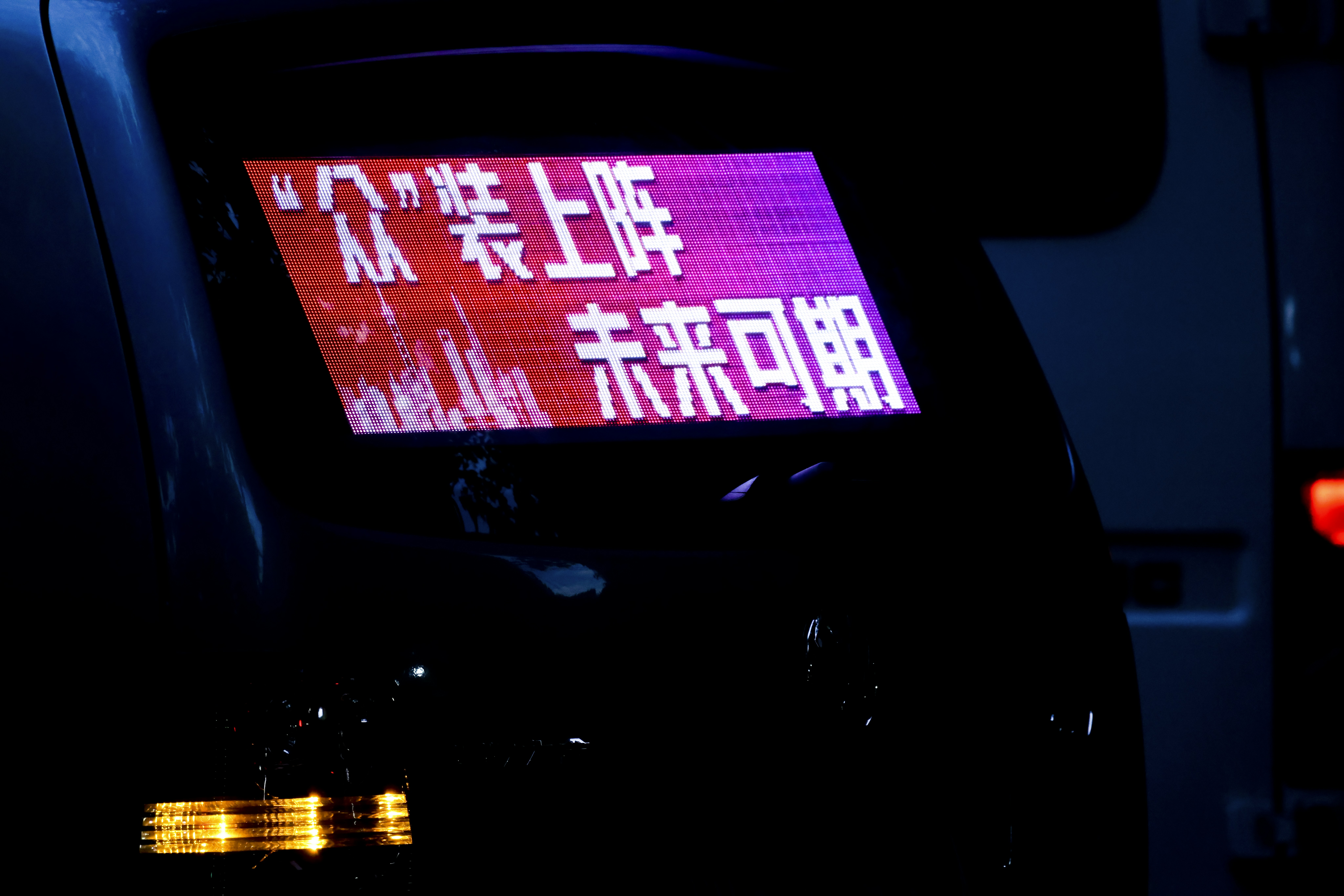 Neon Mandarin Sign on a Black Car at Night