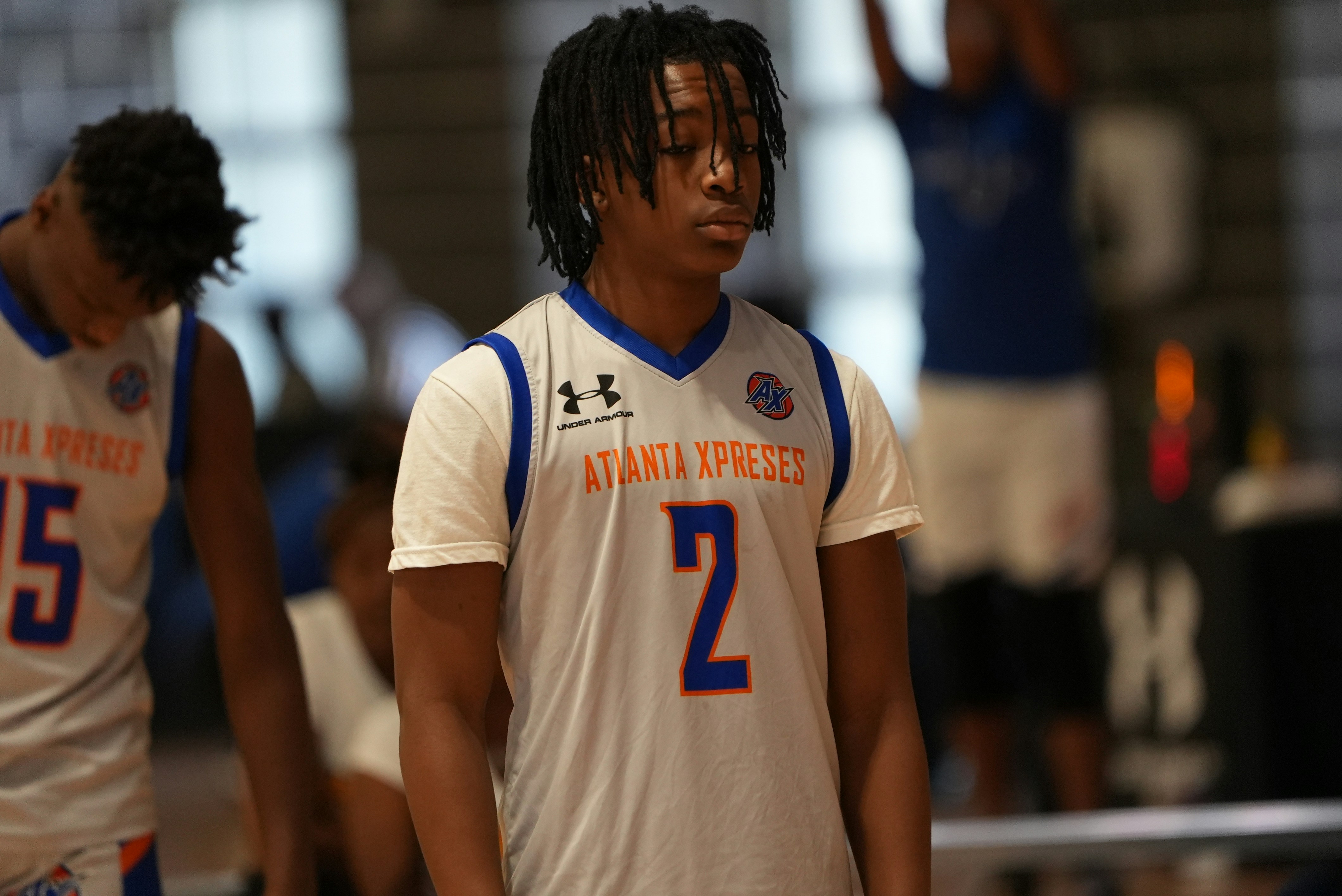 A basketball player with dreadlocks standing next to another player ...