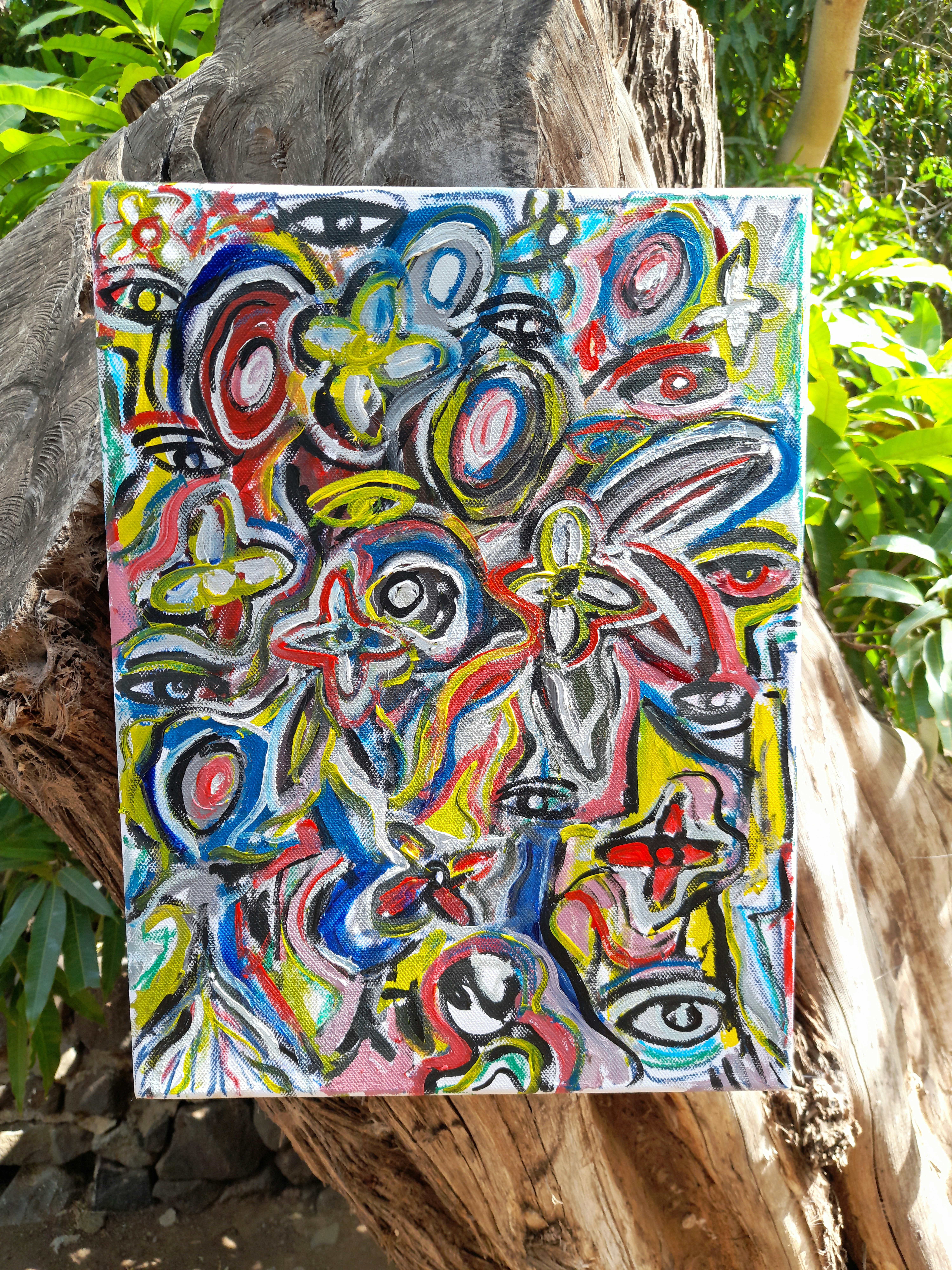 Graffiti-Style Canvas Portrait Resting Against a Tree Trunk