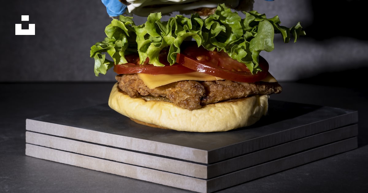 青い手袋をはめた手がハンバーガーに手を伸ばすの写真 Unsplashの食べ物の無料画像
