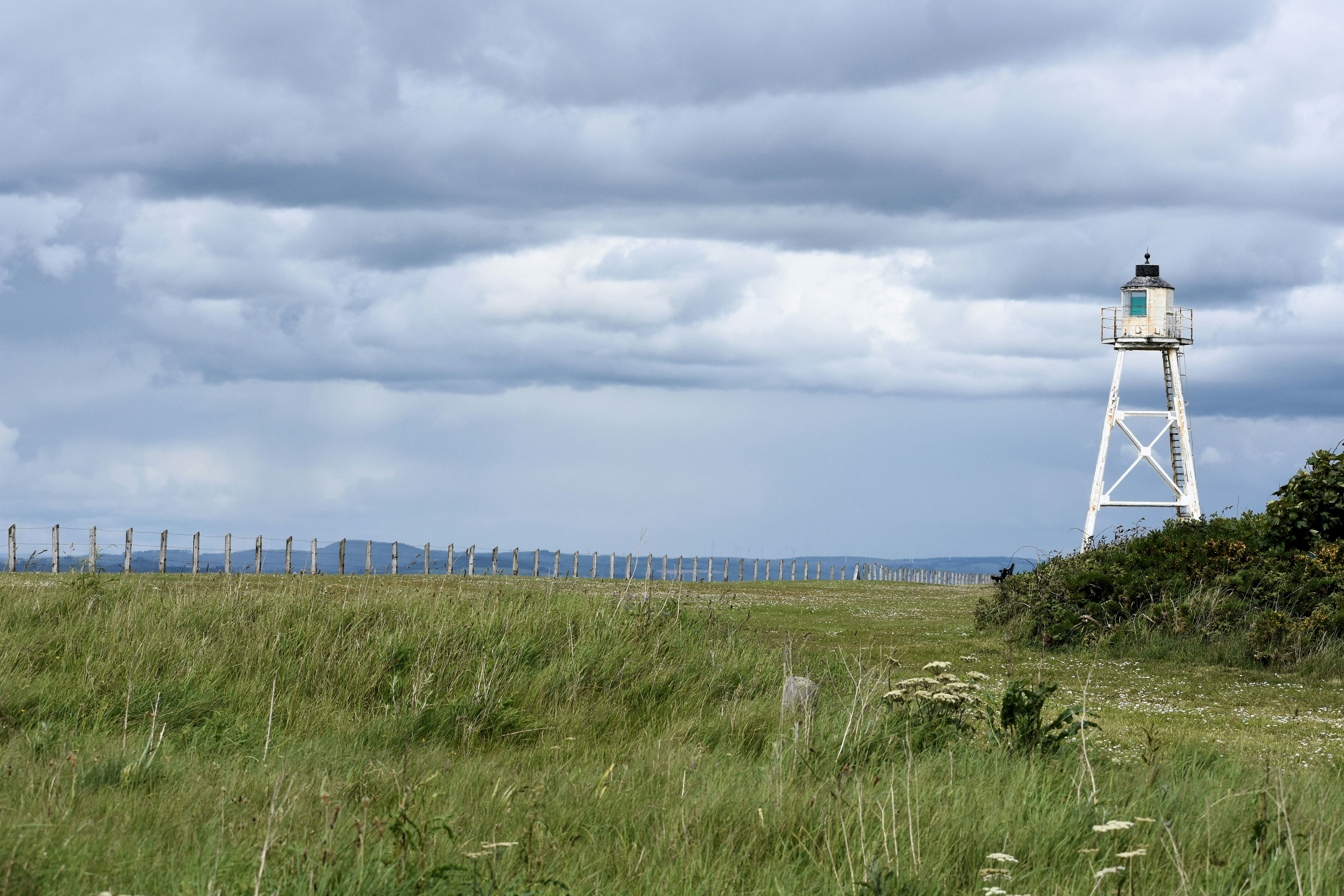 A white lighthouse on top of a grassy hill photo – Free Silloth Image ...