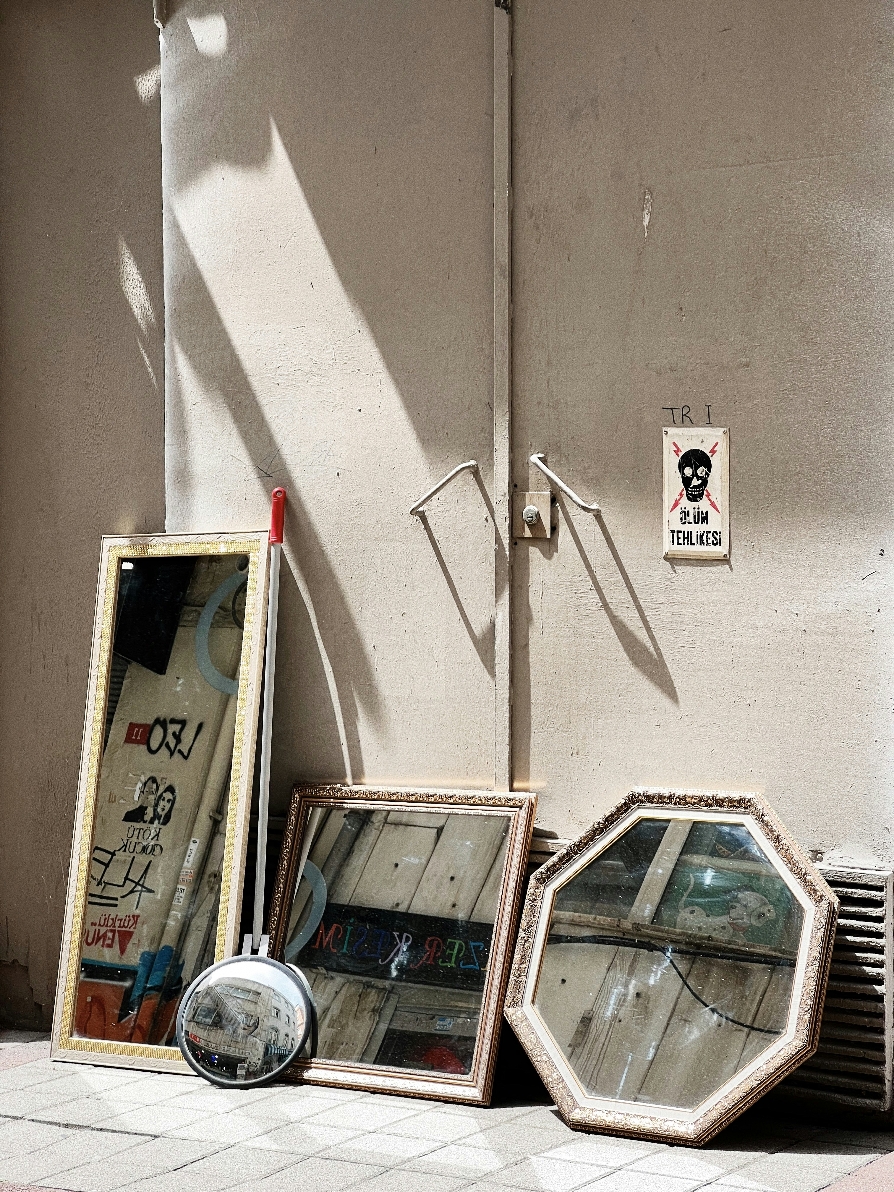 A group of mirrors sitting on the side of a building photo – Free ...