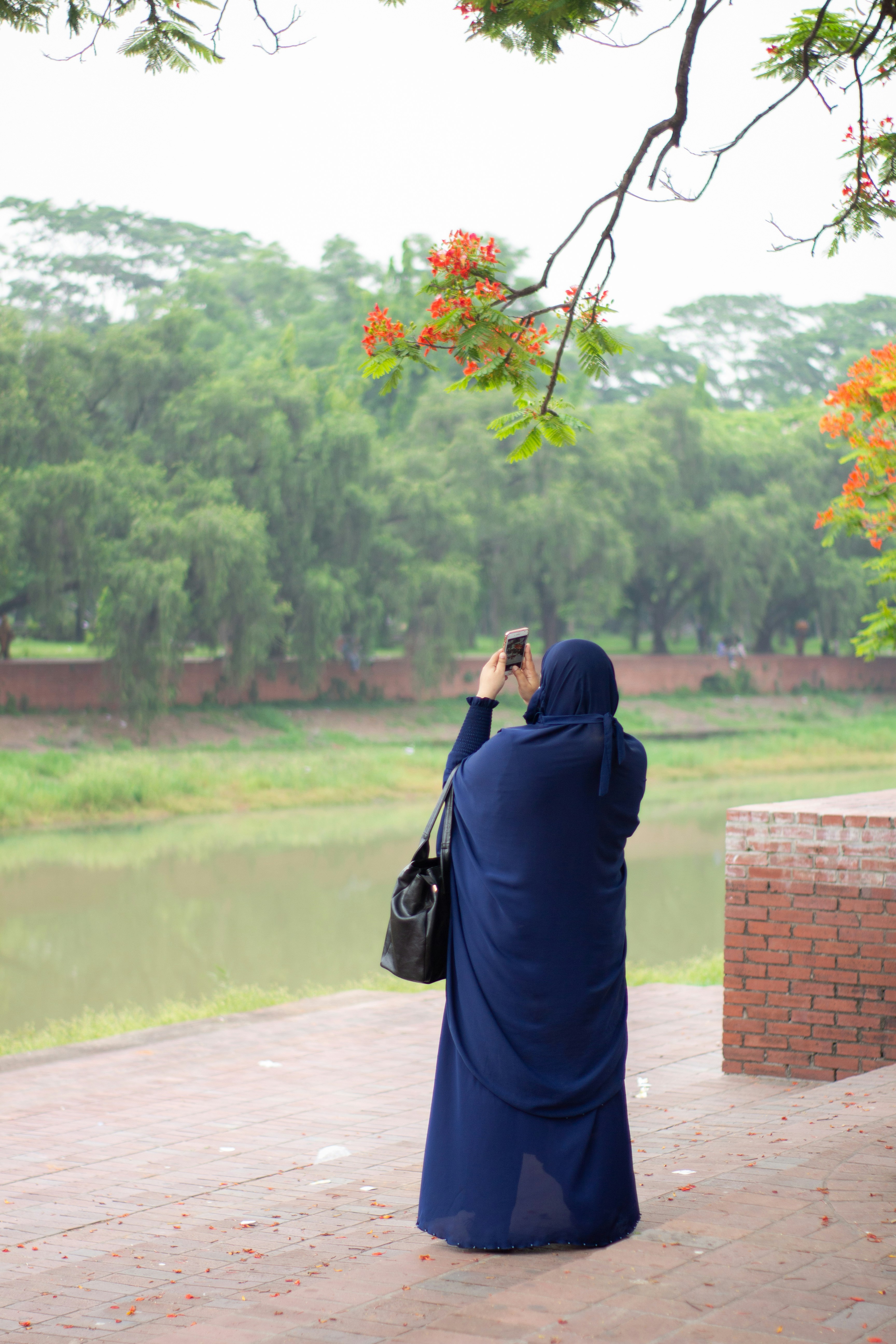 Blue Robe Silhouette: A Woman Capturing a Moment by the Riverside