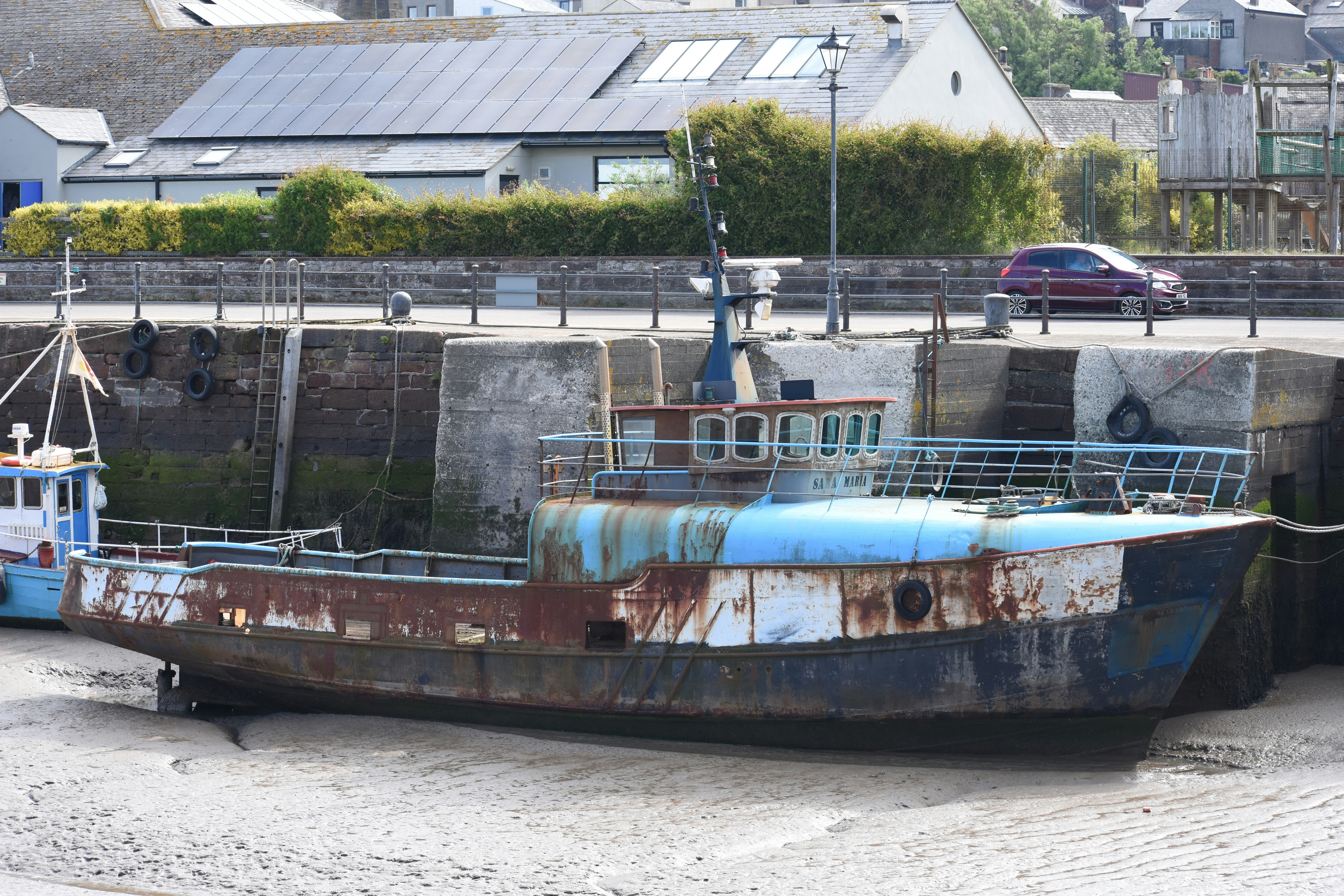 A rusted boat sitting on top of a sandy beach photo – Free Maryport ...