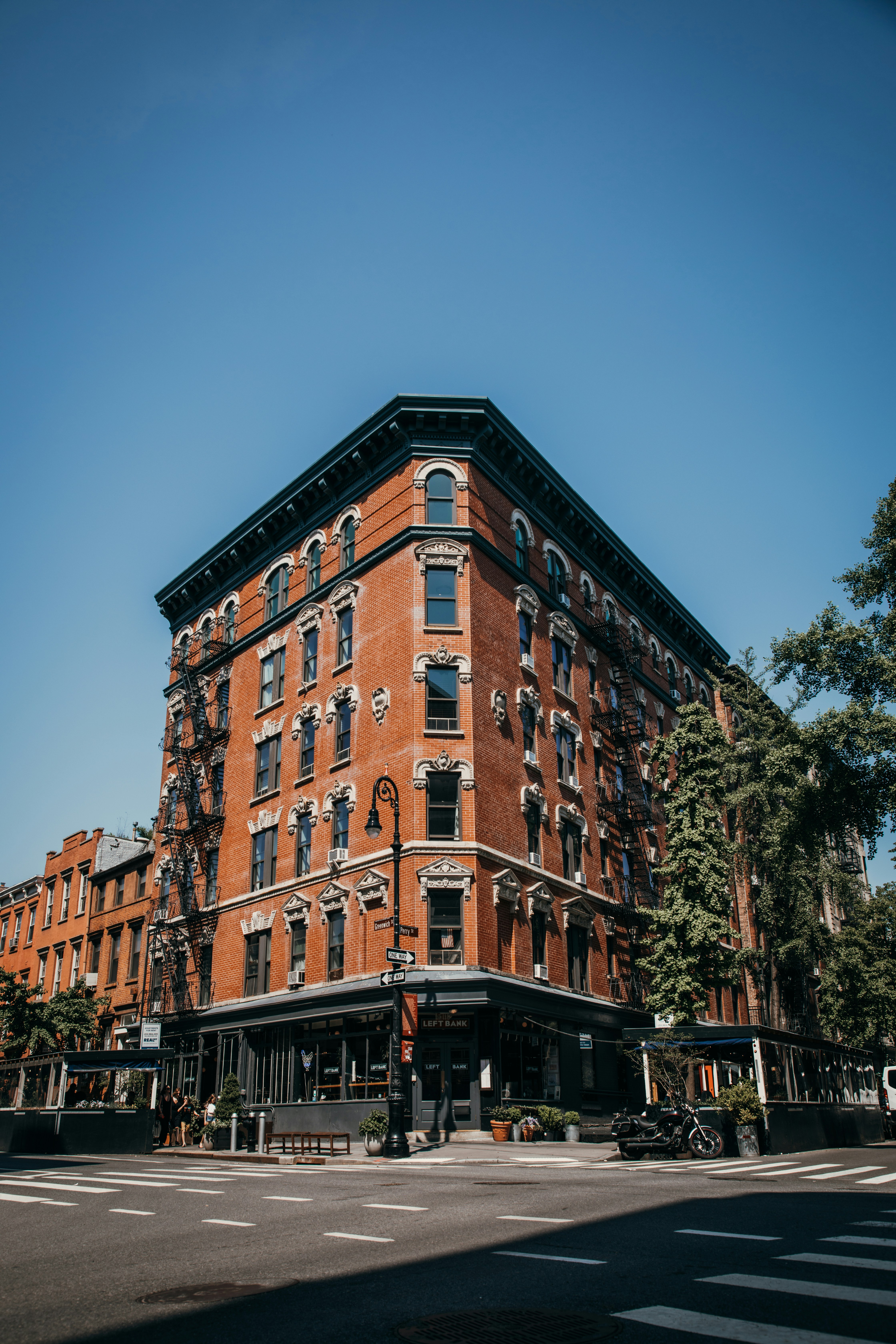 A tall red brick building sitting on the corner of a street photo ...