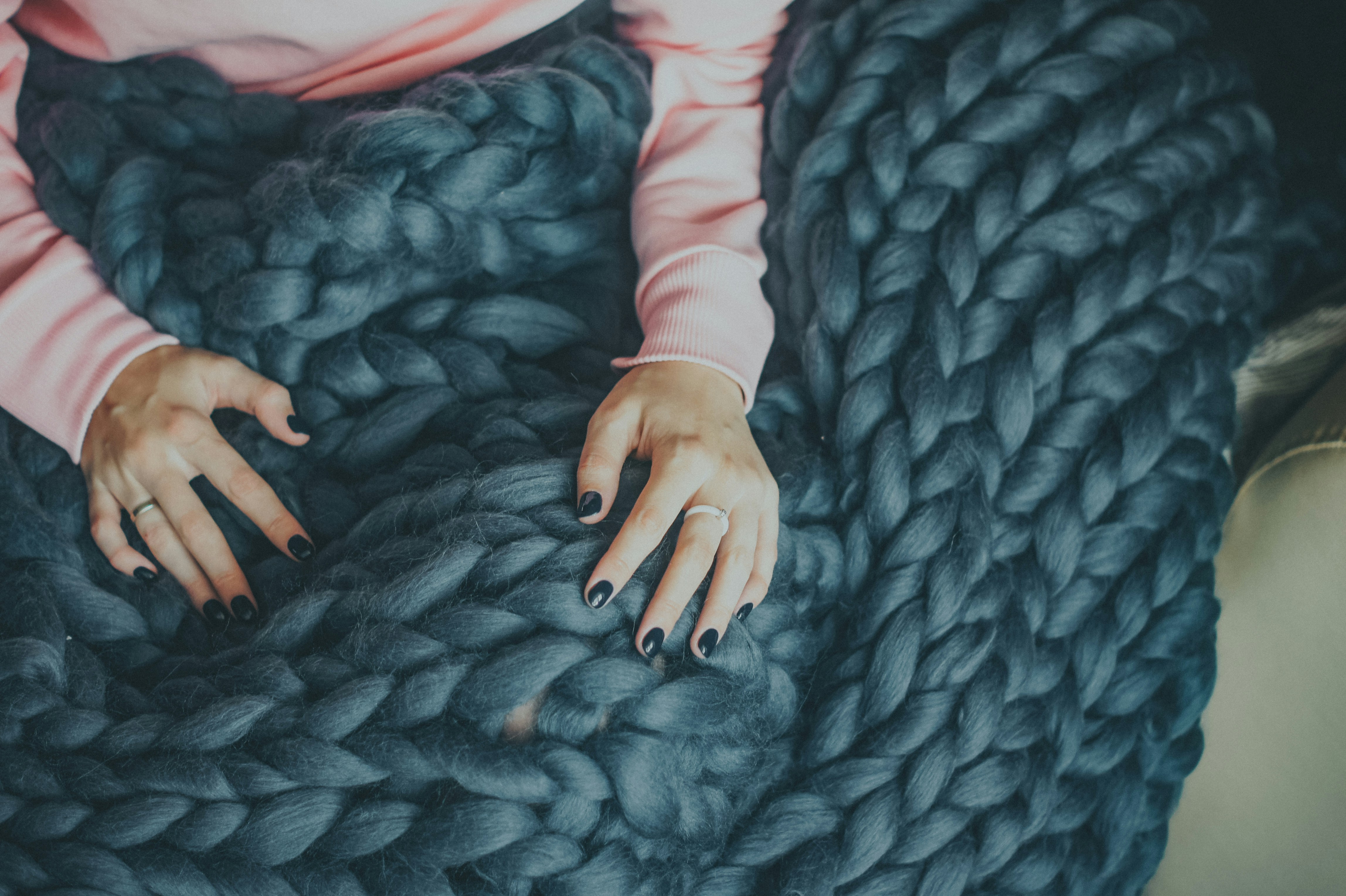 Pink-Sleeved Pause on a Navy Chunky-Knit Blanket