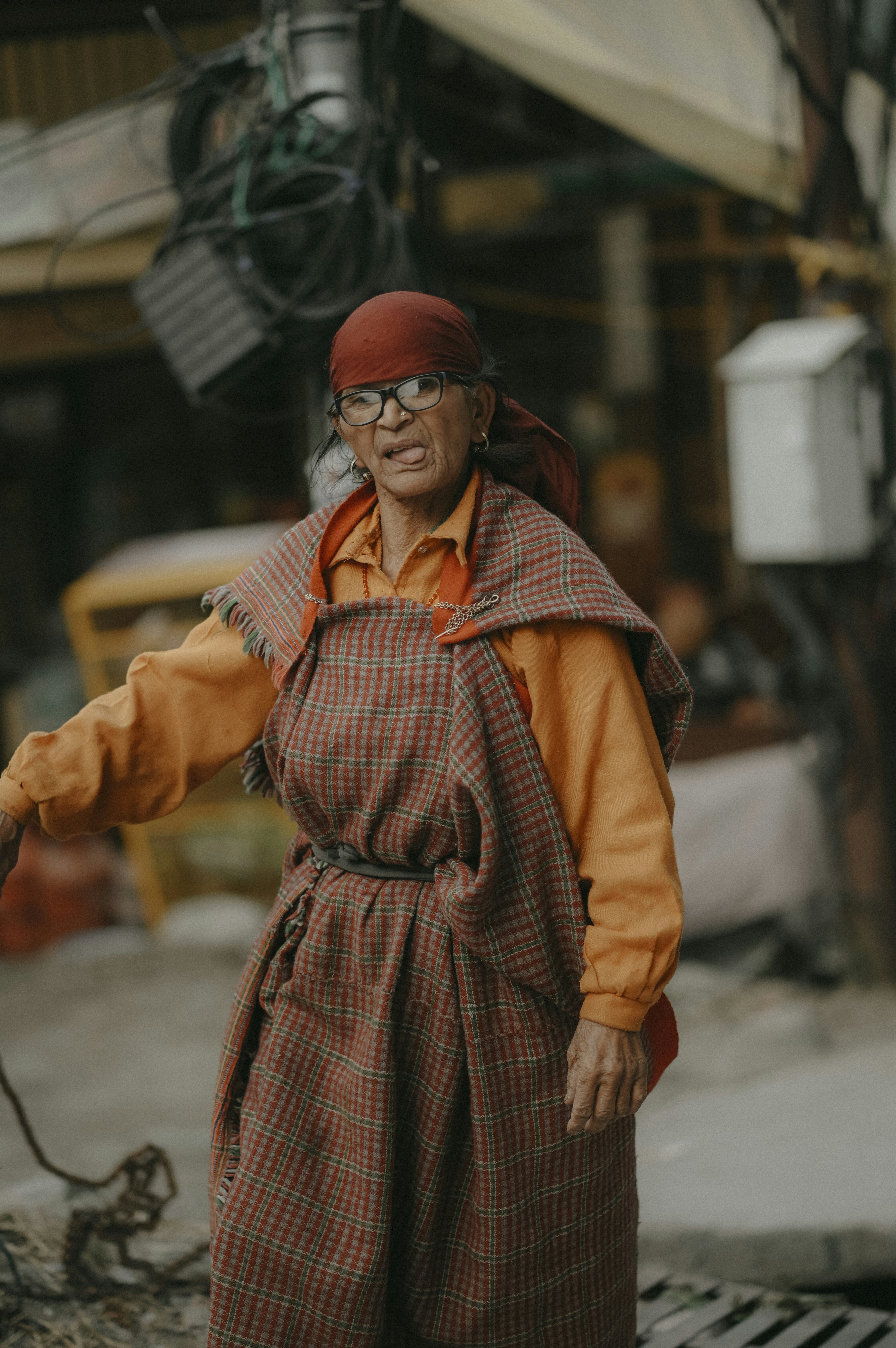 Red Bandana and Plaid Apron: A Pensioner Vendor in a Bustling Street