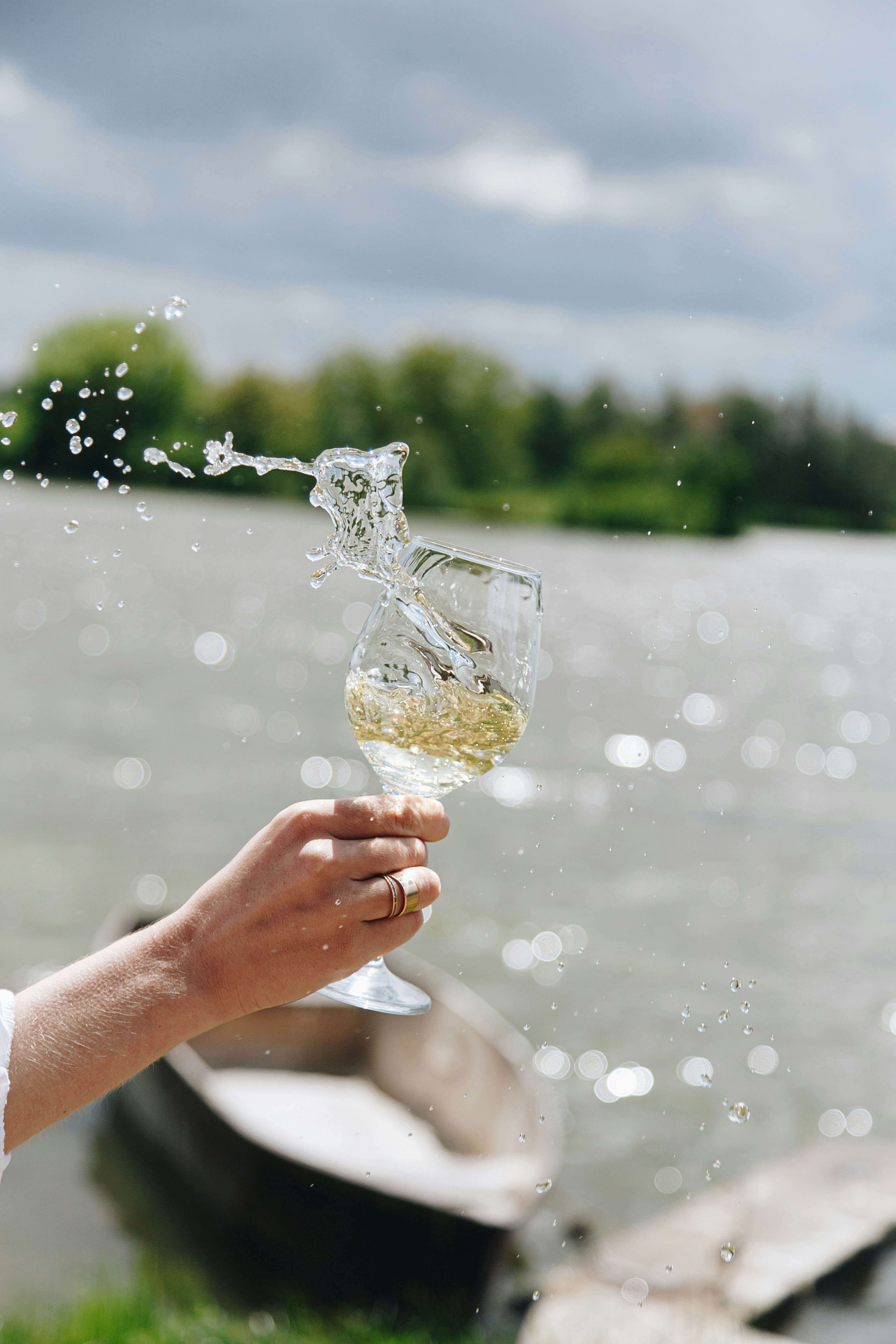 a person holding a wine glass with water splashing out of it