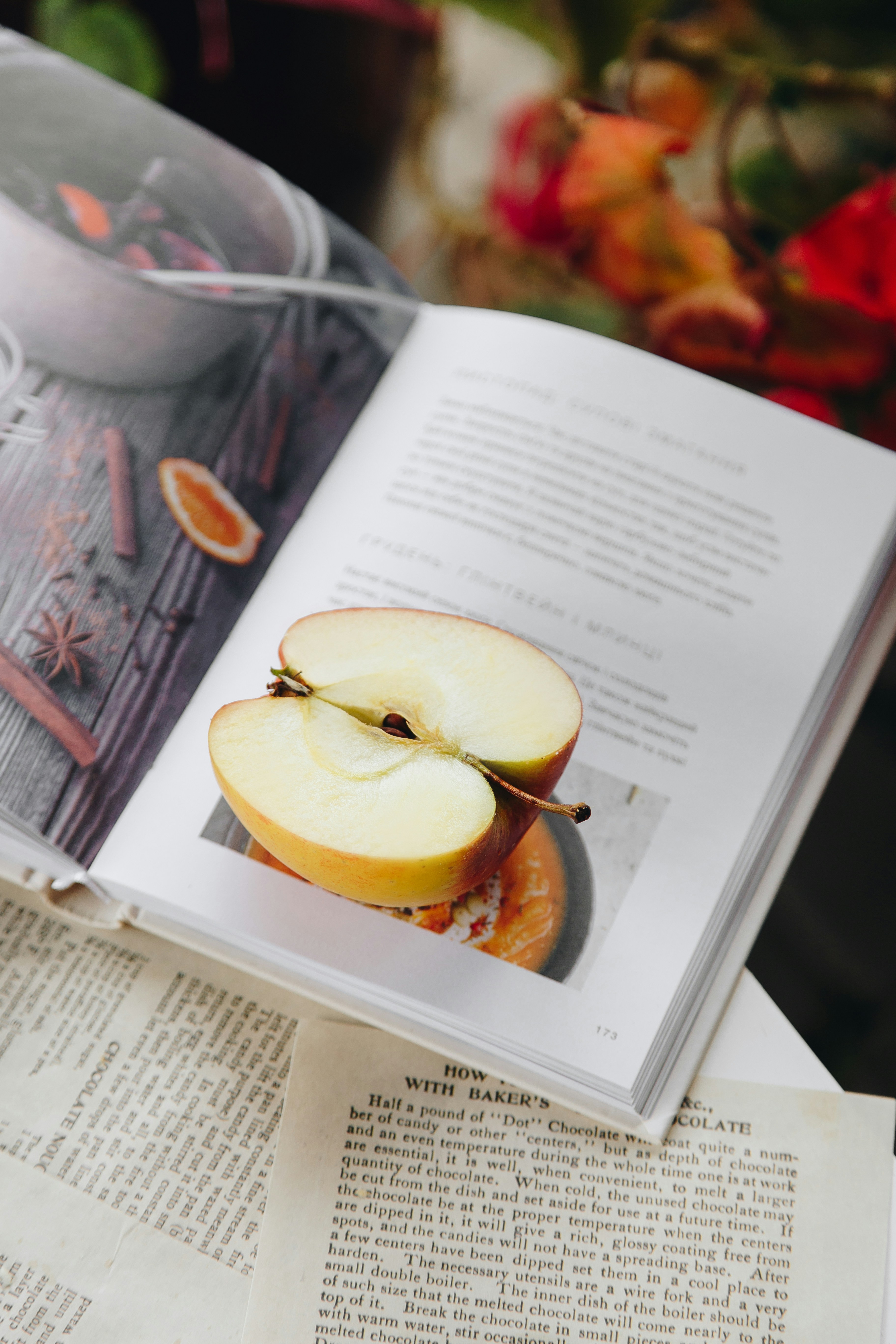 Open cookbook reveals a sliced apple resting on a pastry base