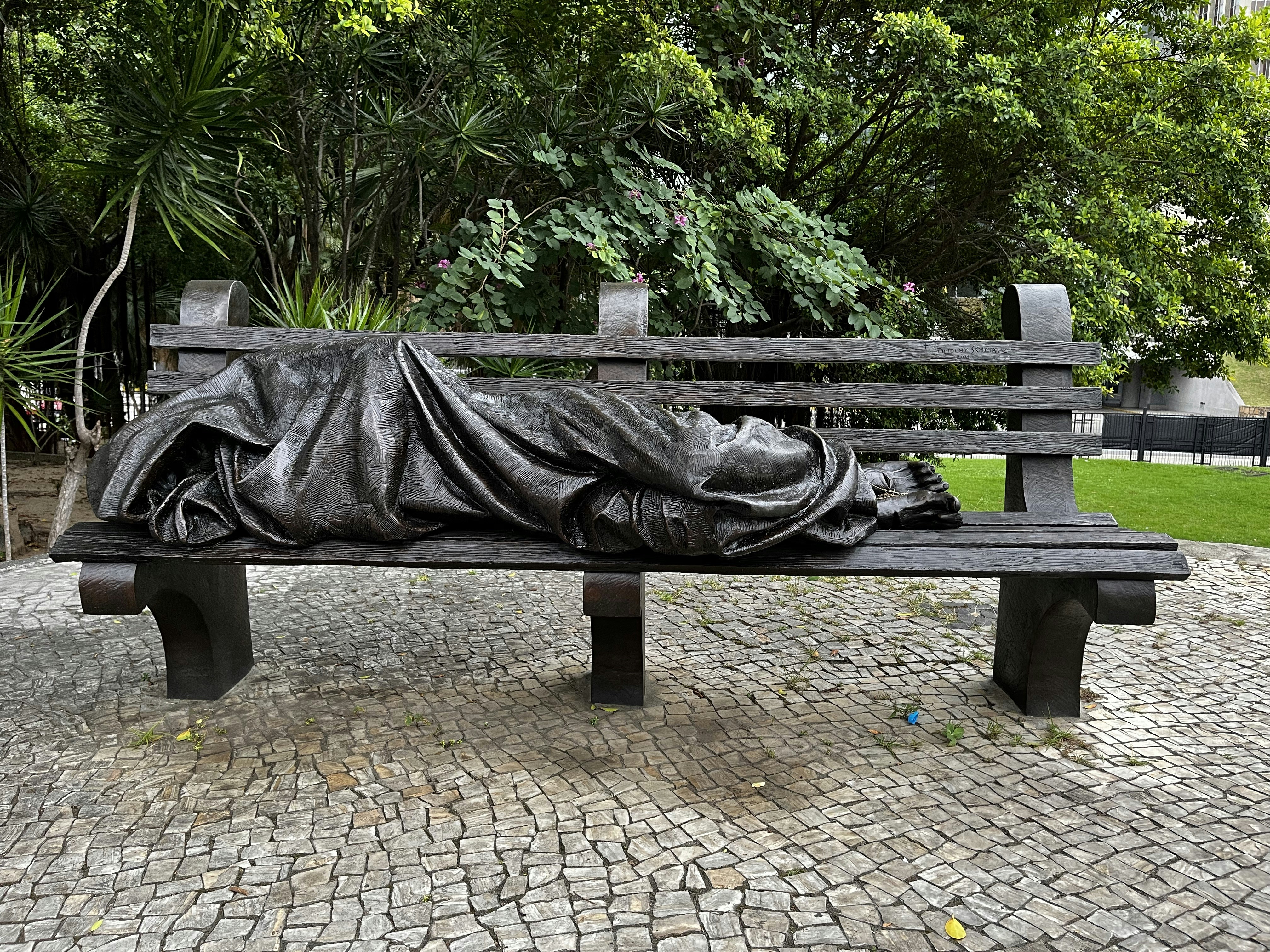 A statue of a person laying on a park bench photo – Free Rio de janeiro ...