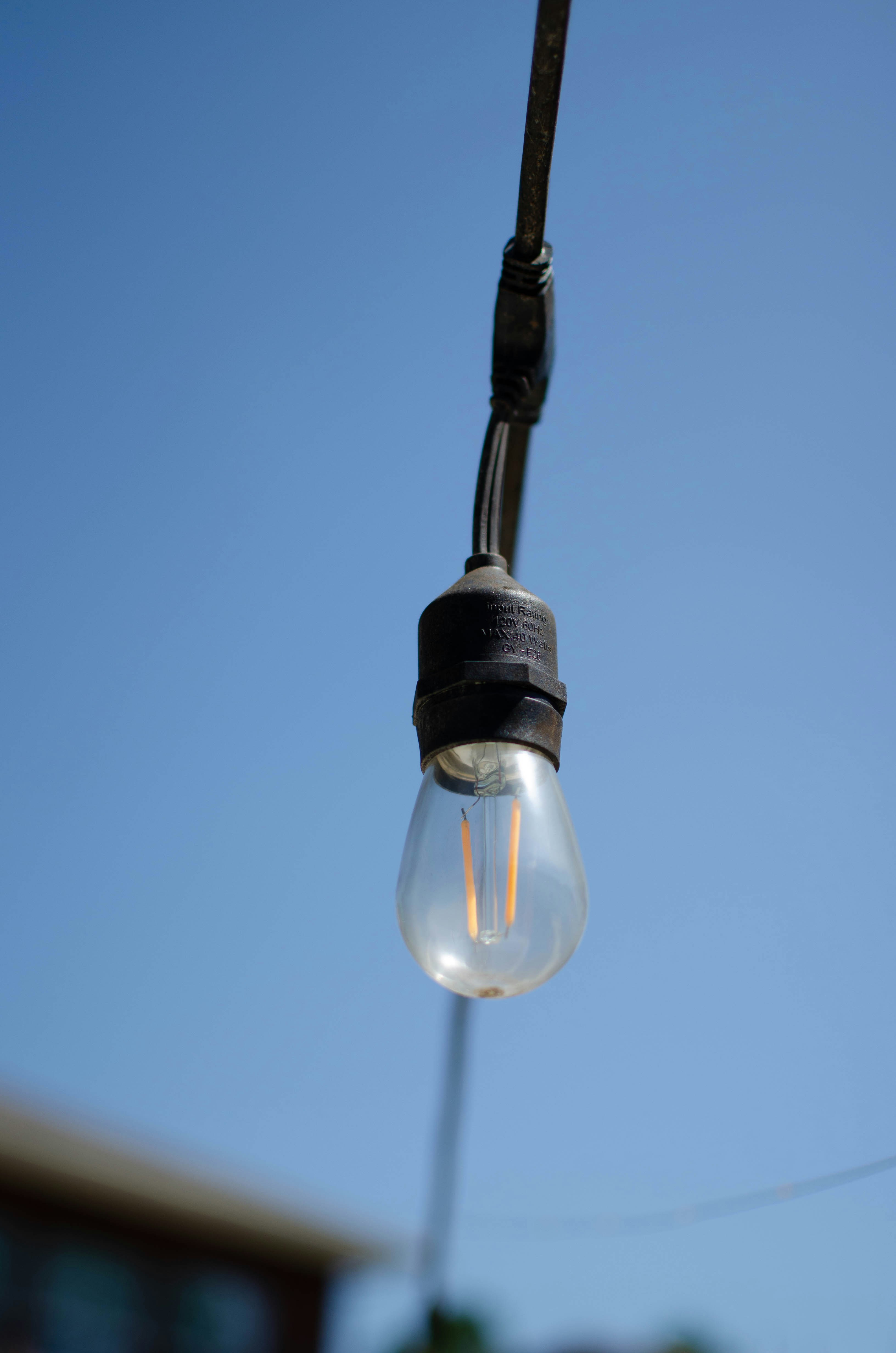 Lone Lightbulb Against a Clear Sky: A Minimalist Moment of Illumination