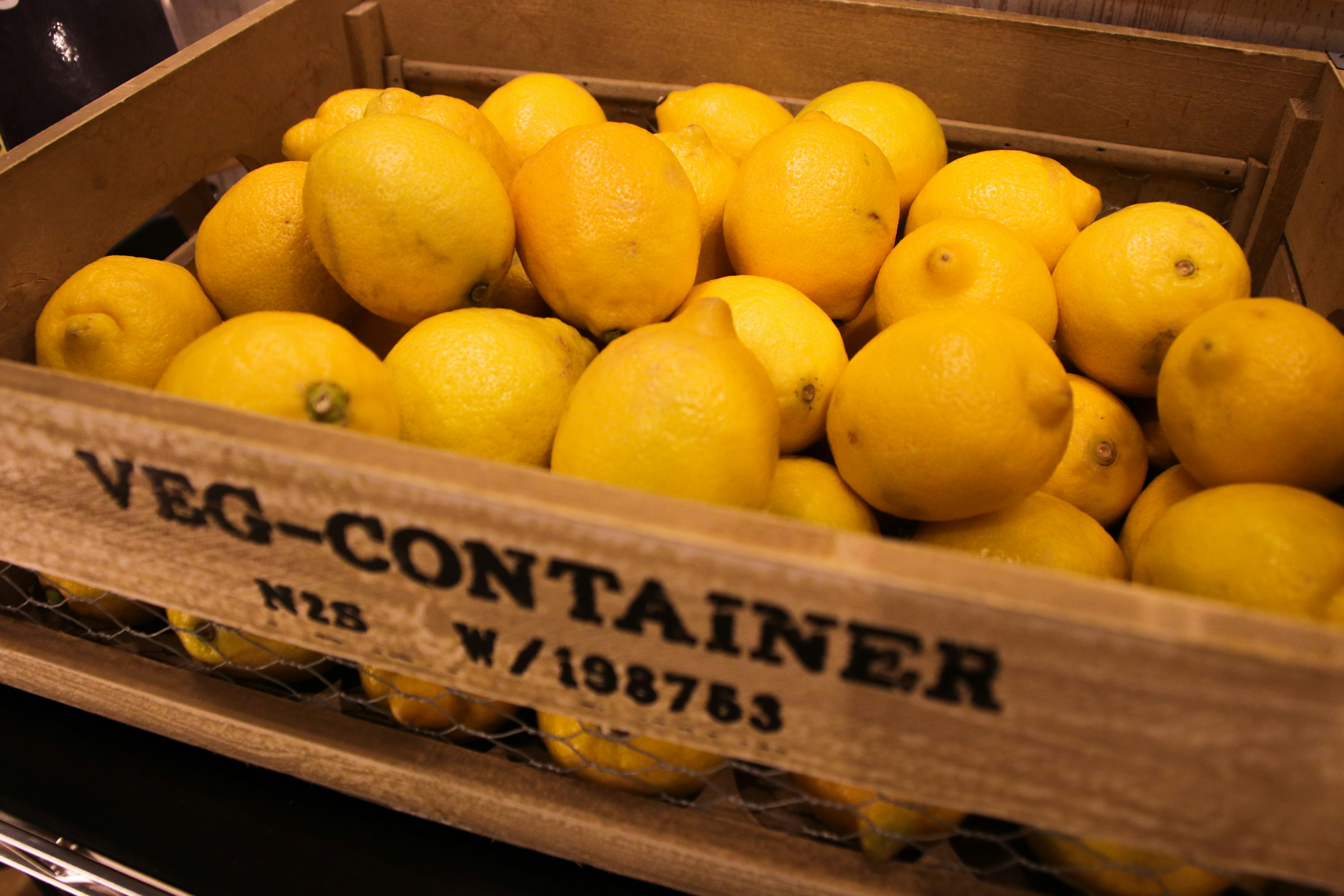 A crate full of lemons sitting on top of a counter photo – Free Tokyo ...