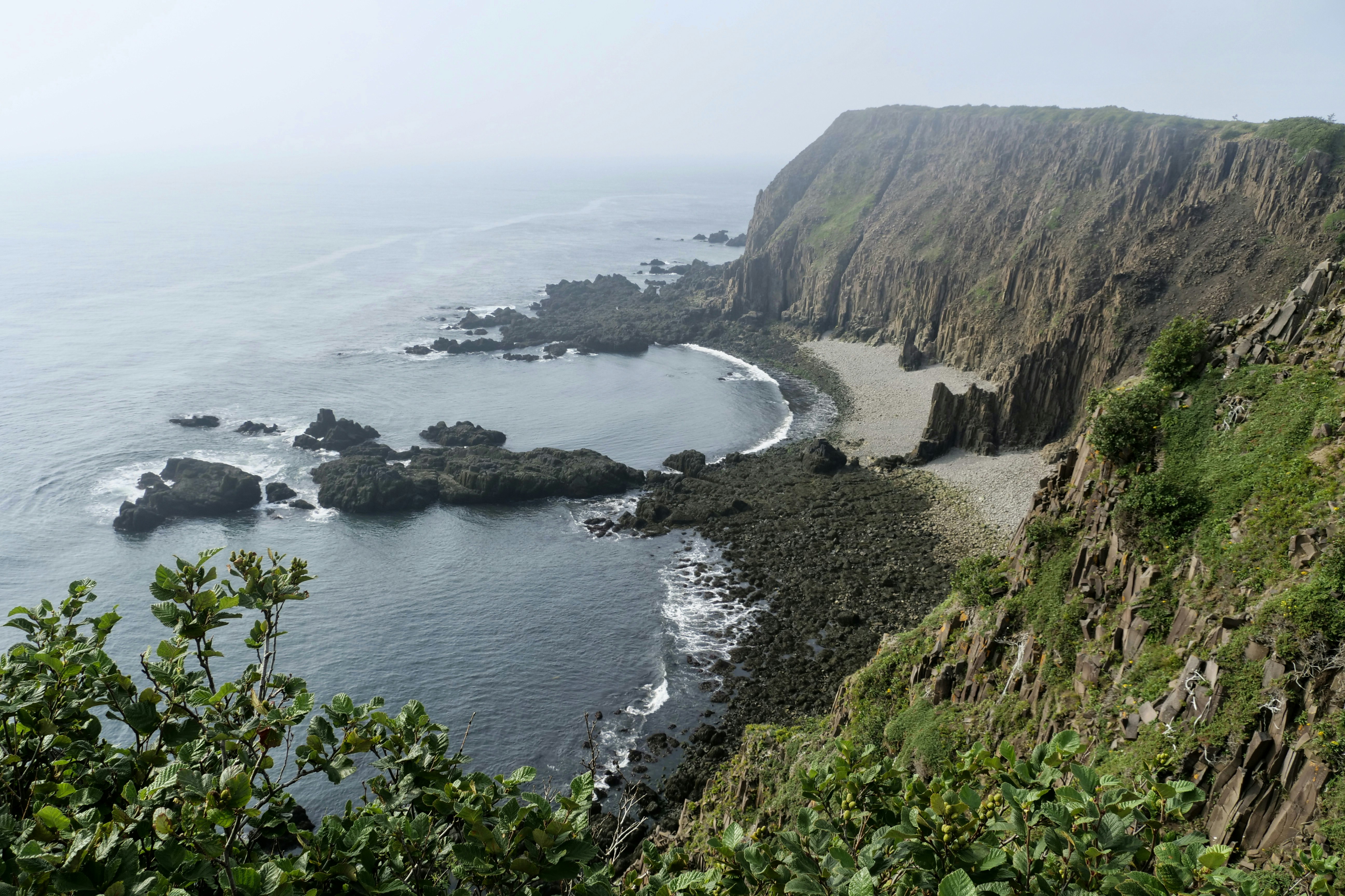 Une falaise rocheuse surplombe l’océan et la plage photo – Photo Océan ...