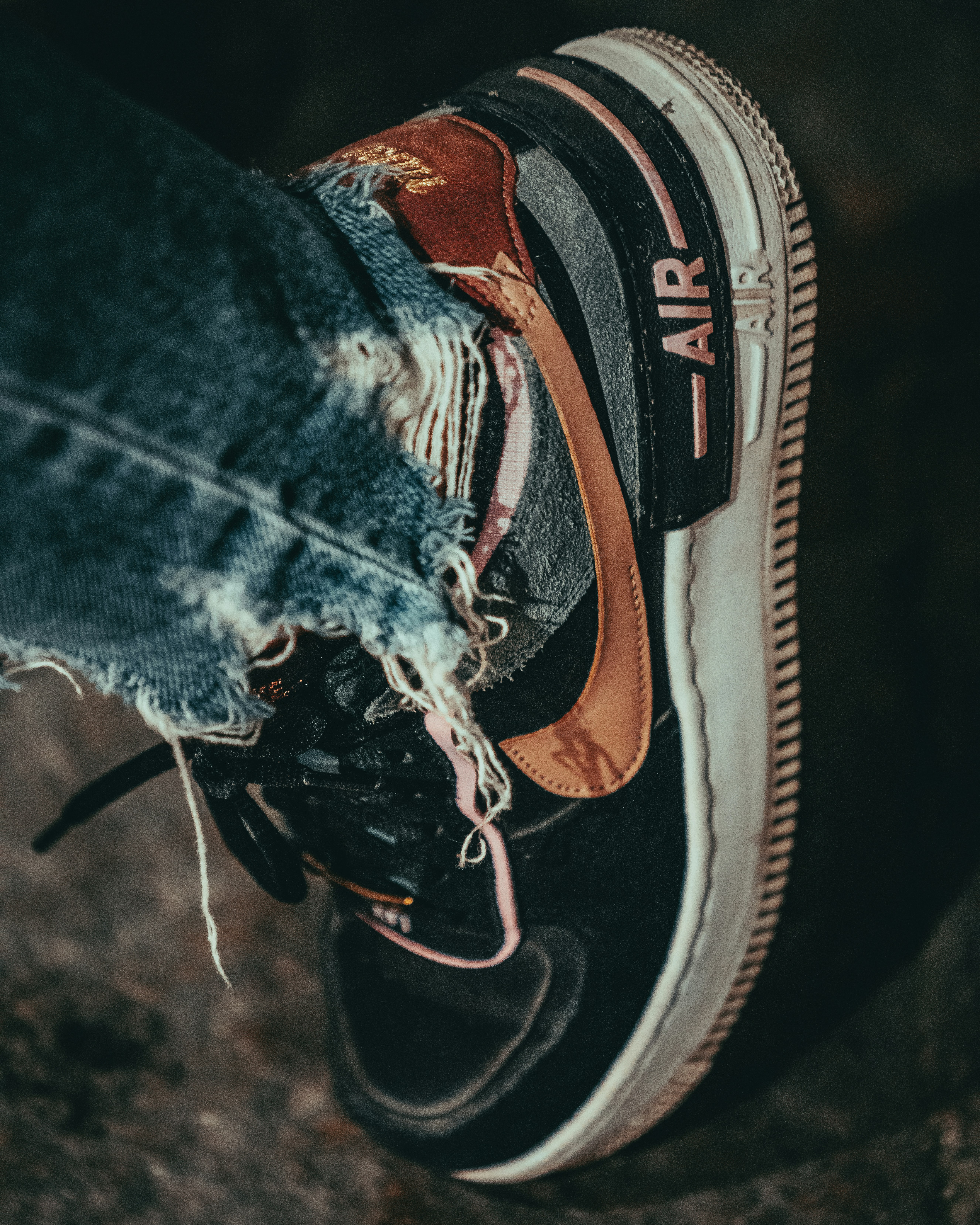 Grounded Steps: A Well-Worn Sneaker and Torn Denim in Focus