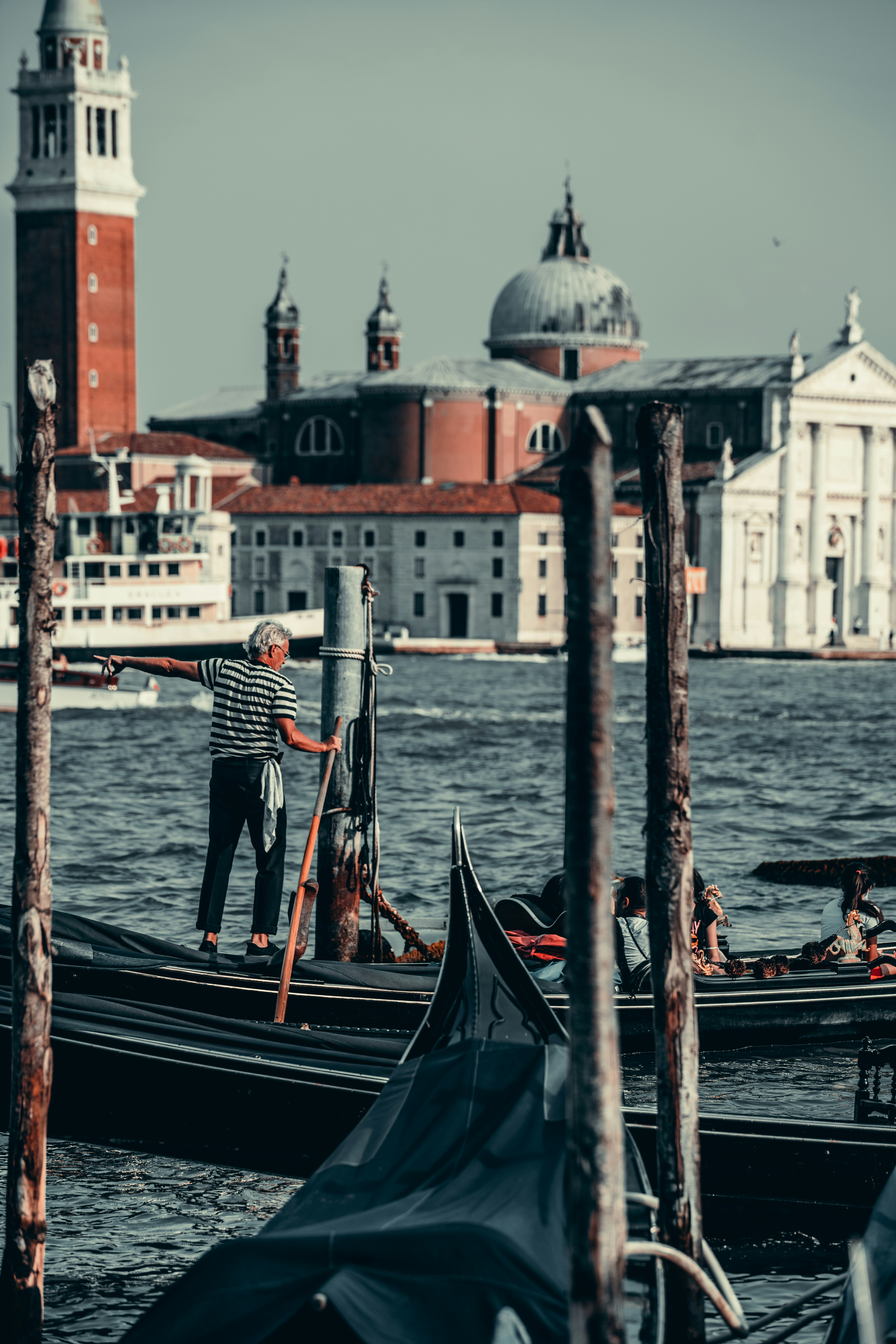 Gondolier on the Edge: Striped Silhouette Against Venice's Canals