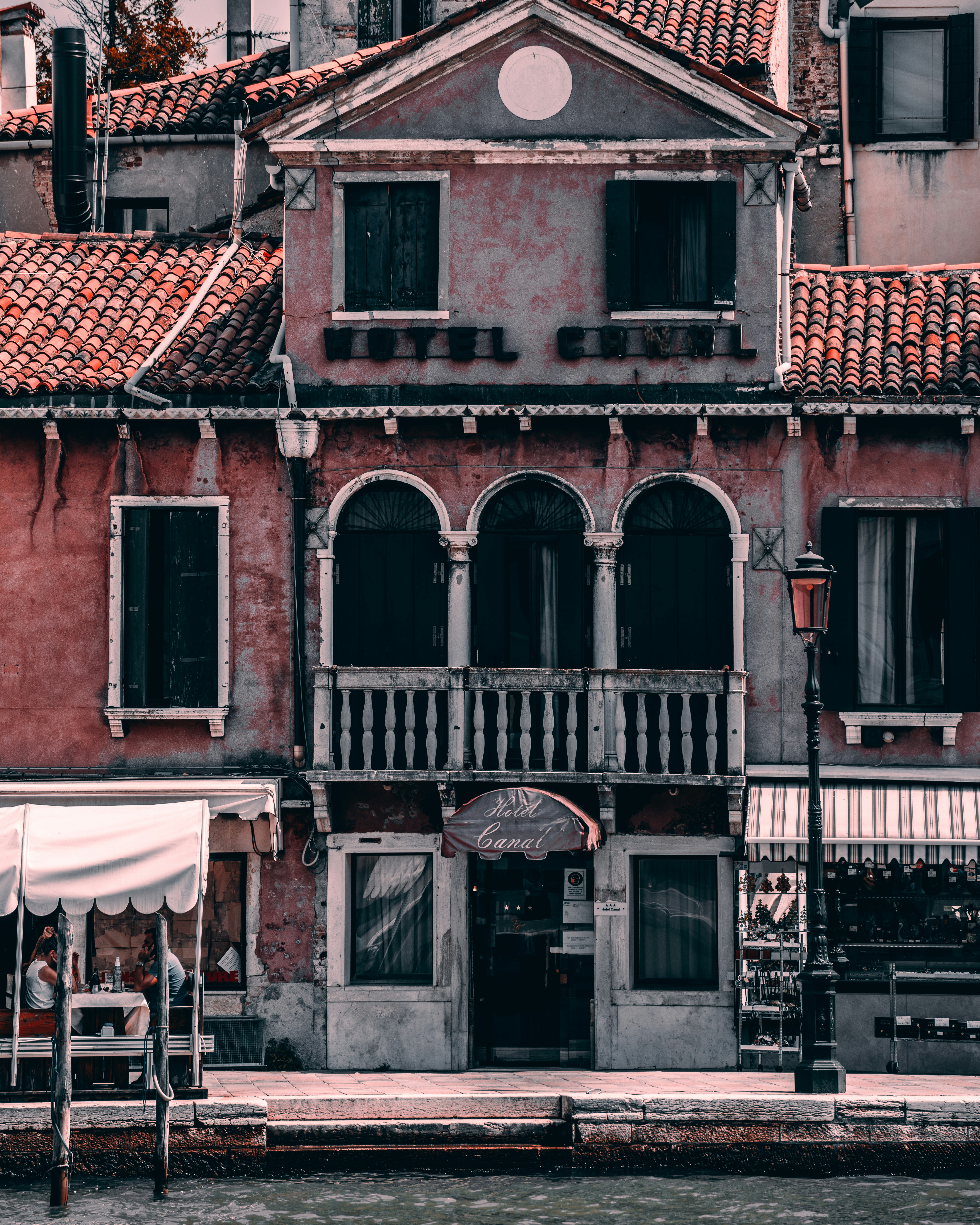 Historic hotel facade with ornate balconies and terracotta roof, reflecting the beauty of Venetian architecture.