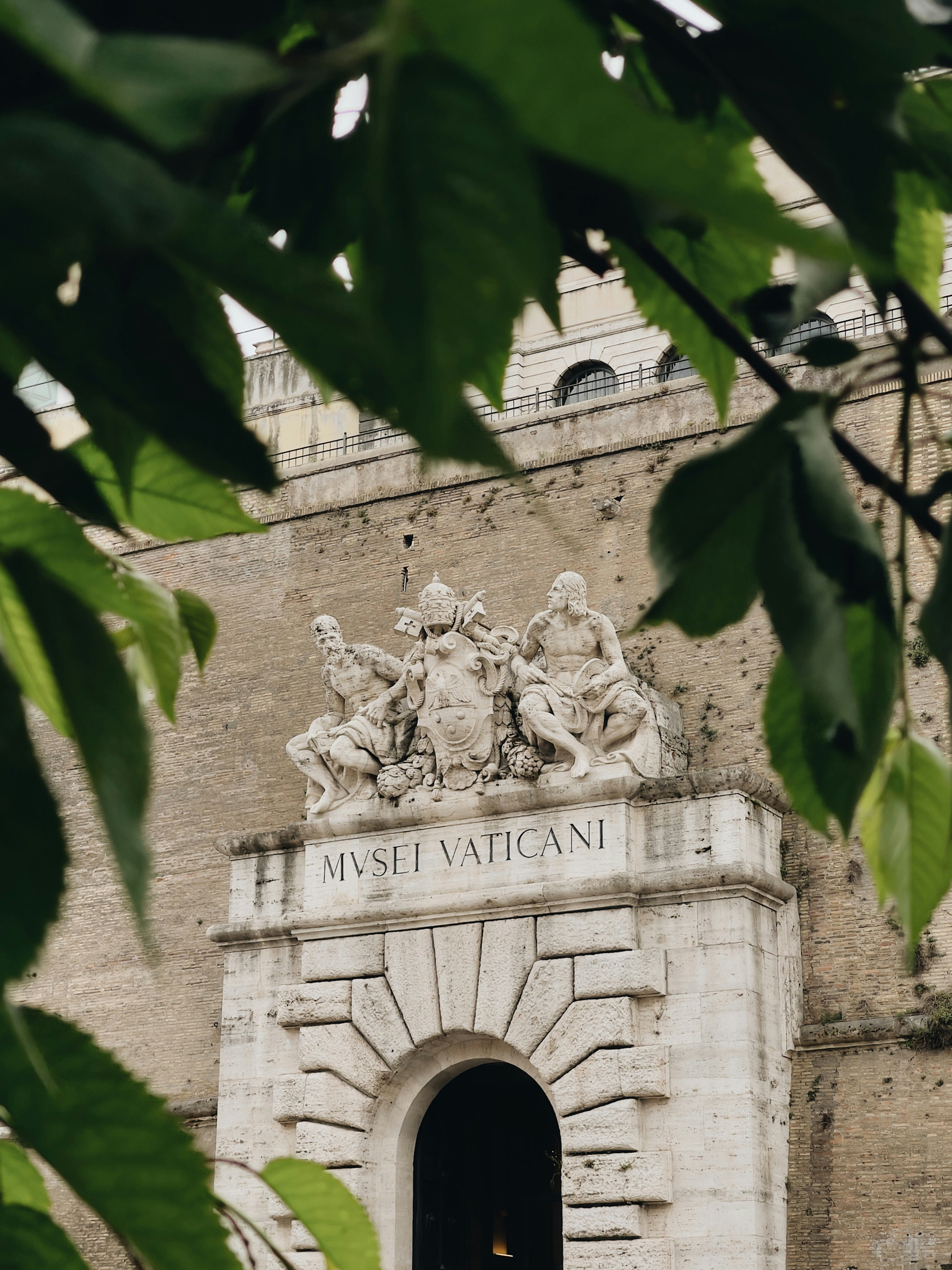 The Vatican Gateway: Stone Guardians Over a Leaf-Framed Arch