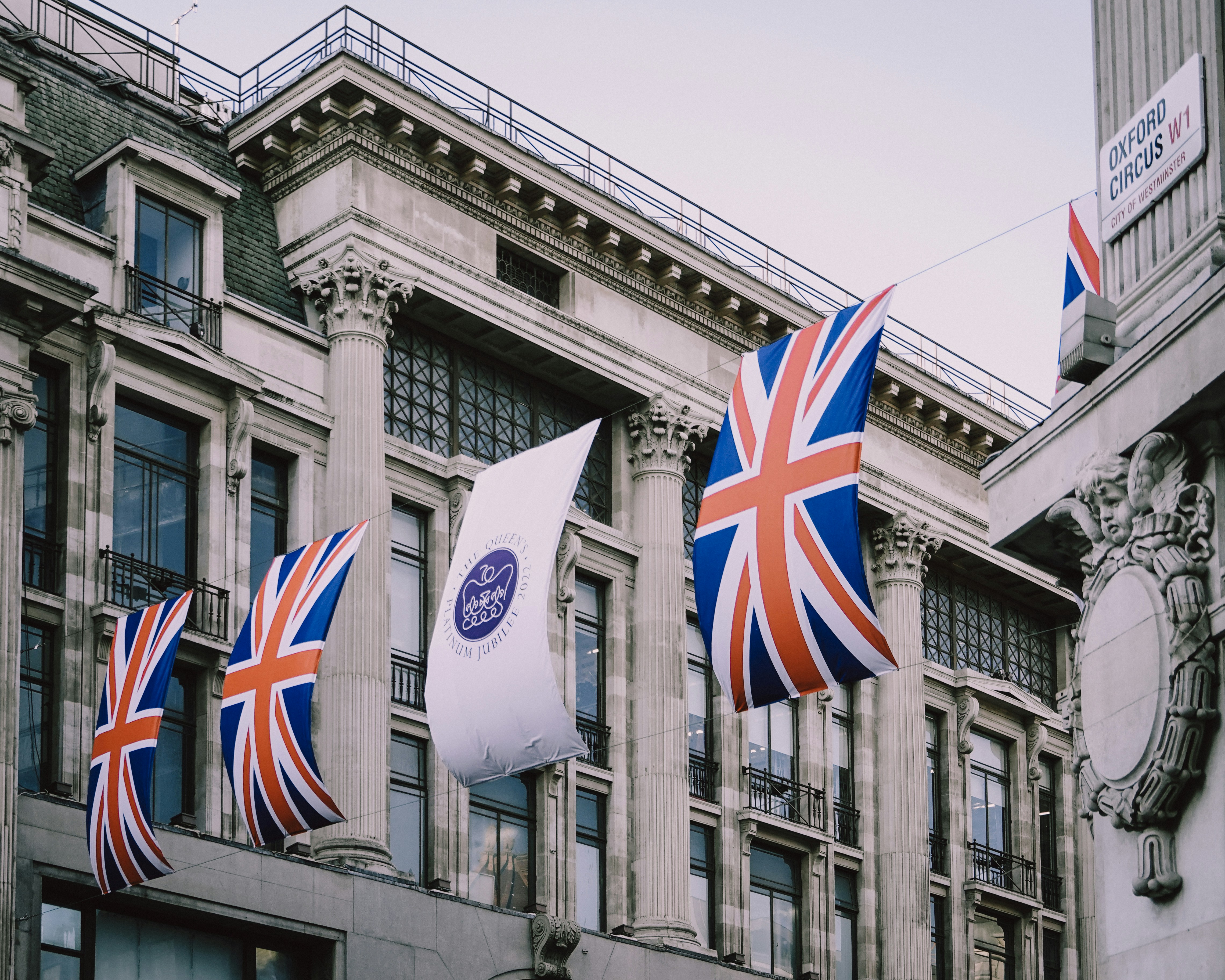 Un groupe de drapeaux flottant devant un bâtiment photo – Photo Drapeau ...