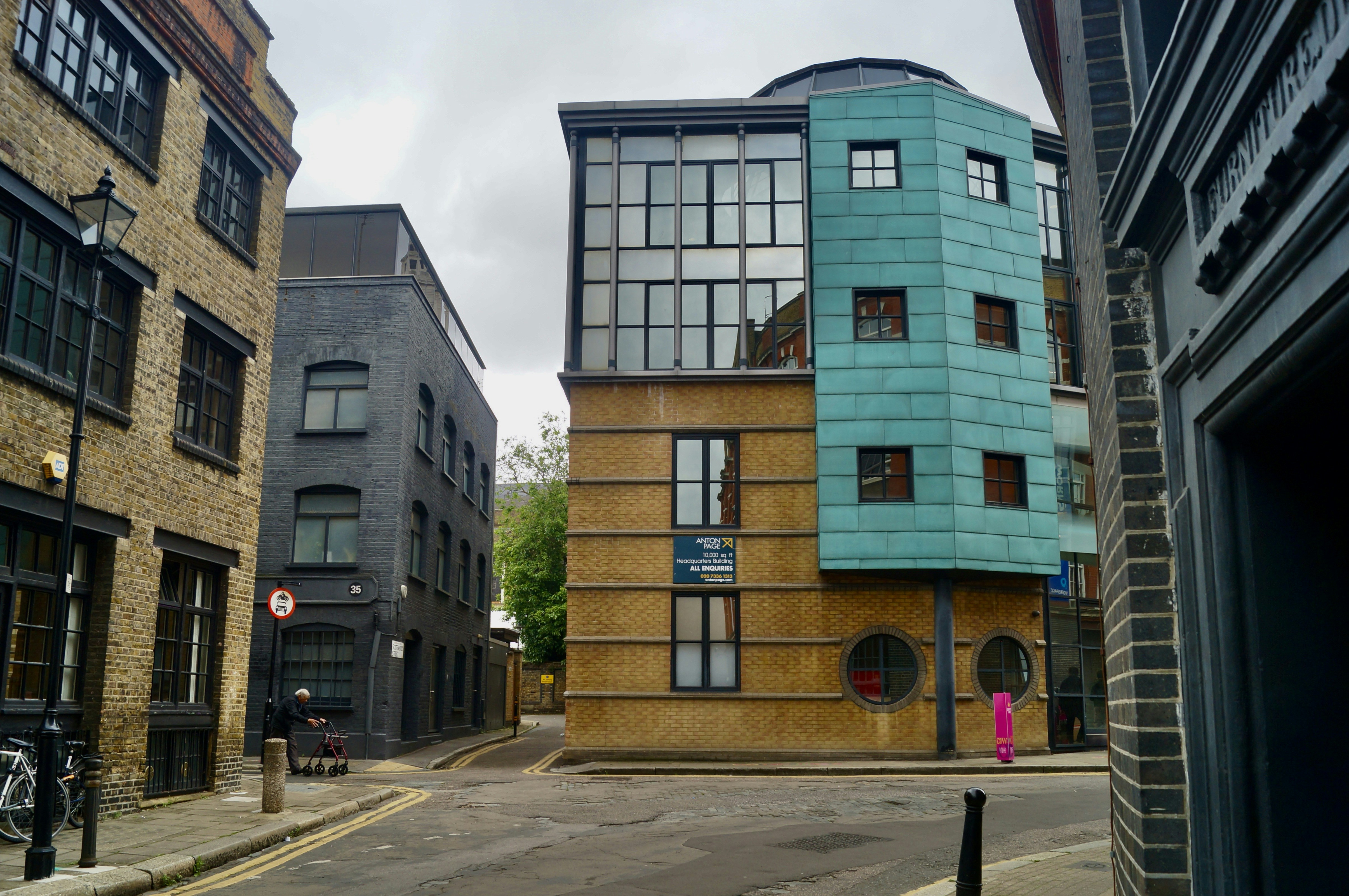 A blue and yellow building on the corner of a street photo – Free High ...