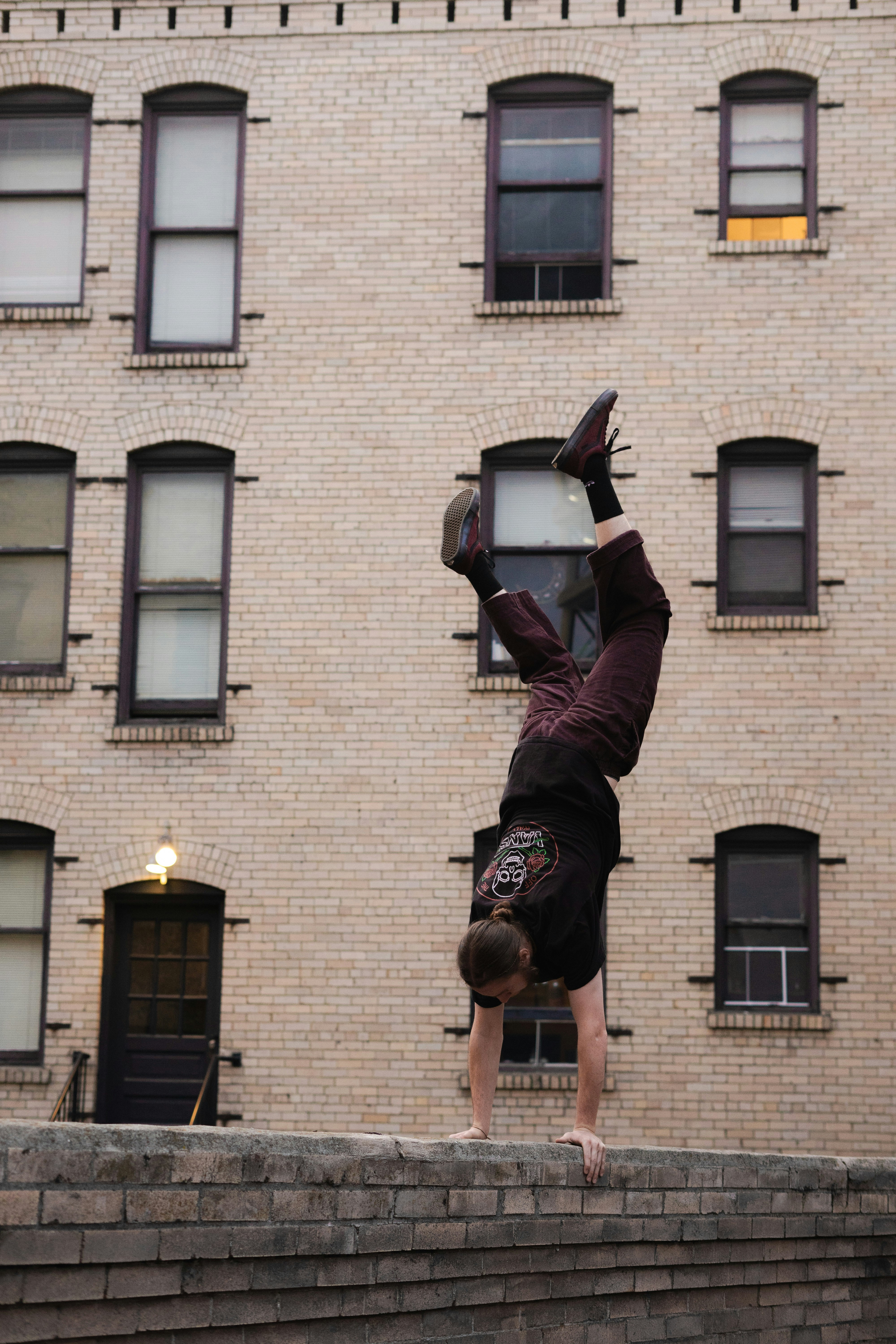 Urban Handstand Above the Brick Wall: An Acrobat's Quiet Defiance