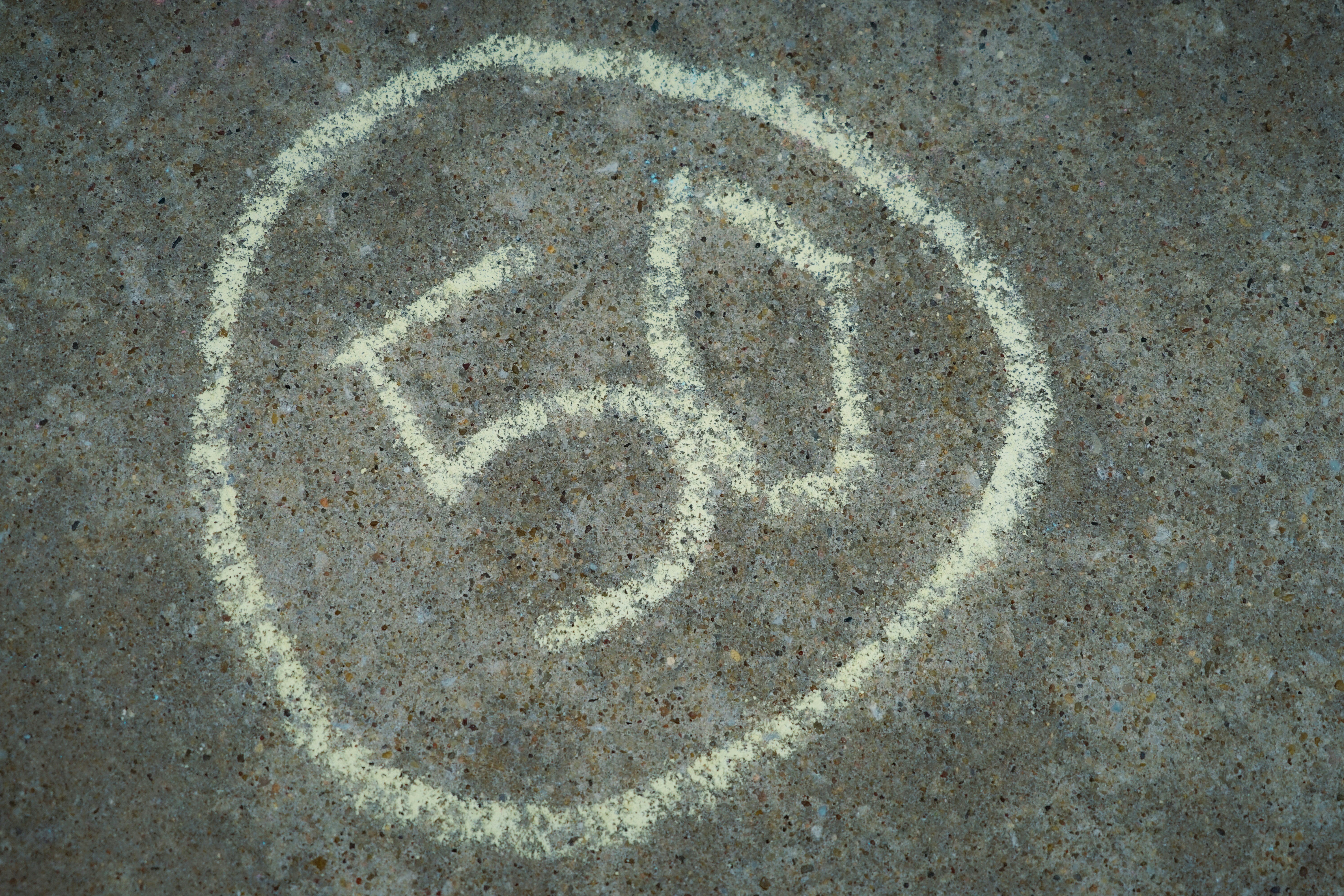 Large chalk number '50' encircled on a concrete surface, showcasing playful street art. The texture of the pavement adds depth to the composition.